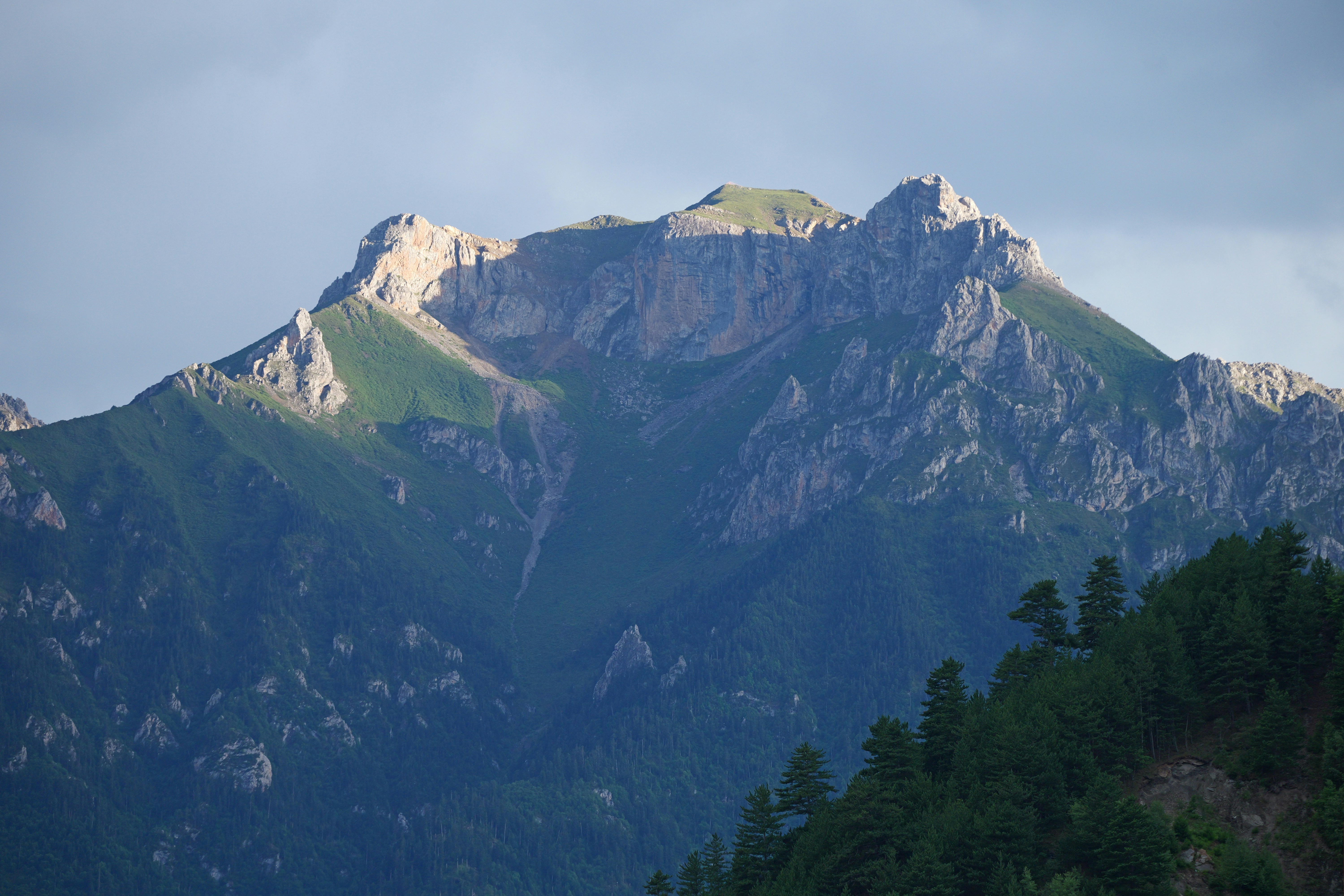 Sunlit Pinnacle: A Mountain Crown Beneath a Shifting Sky