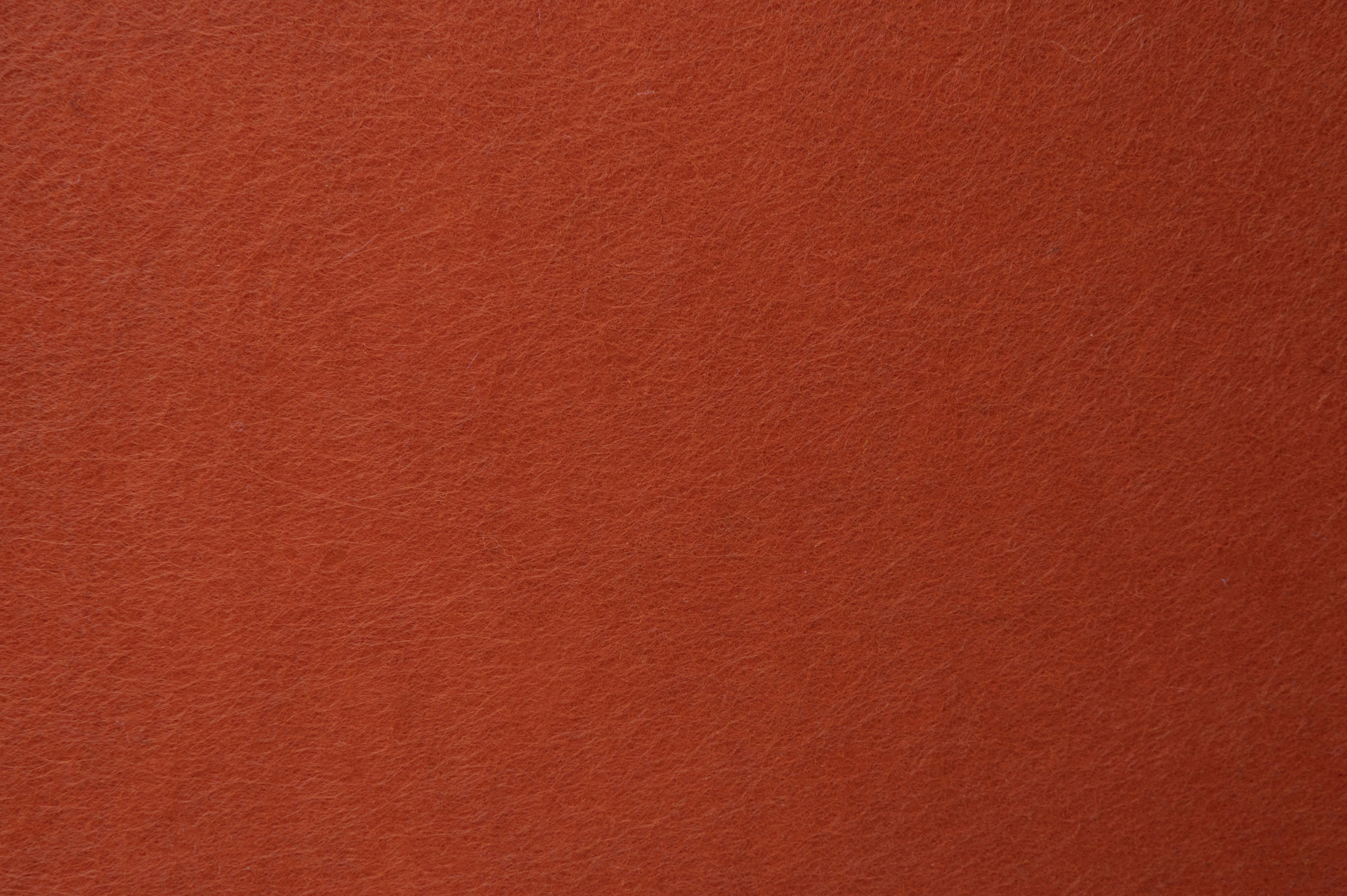 Close-up of a red leather-like texture showing fine grain and subtle color variation. A tactile background suitable for design or branding work.