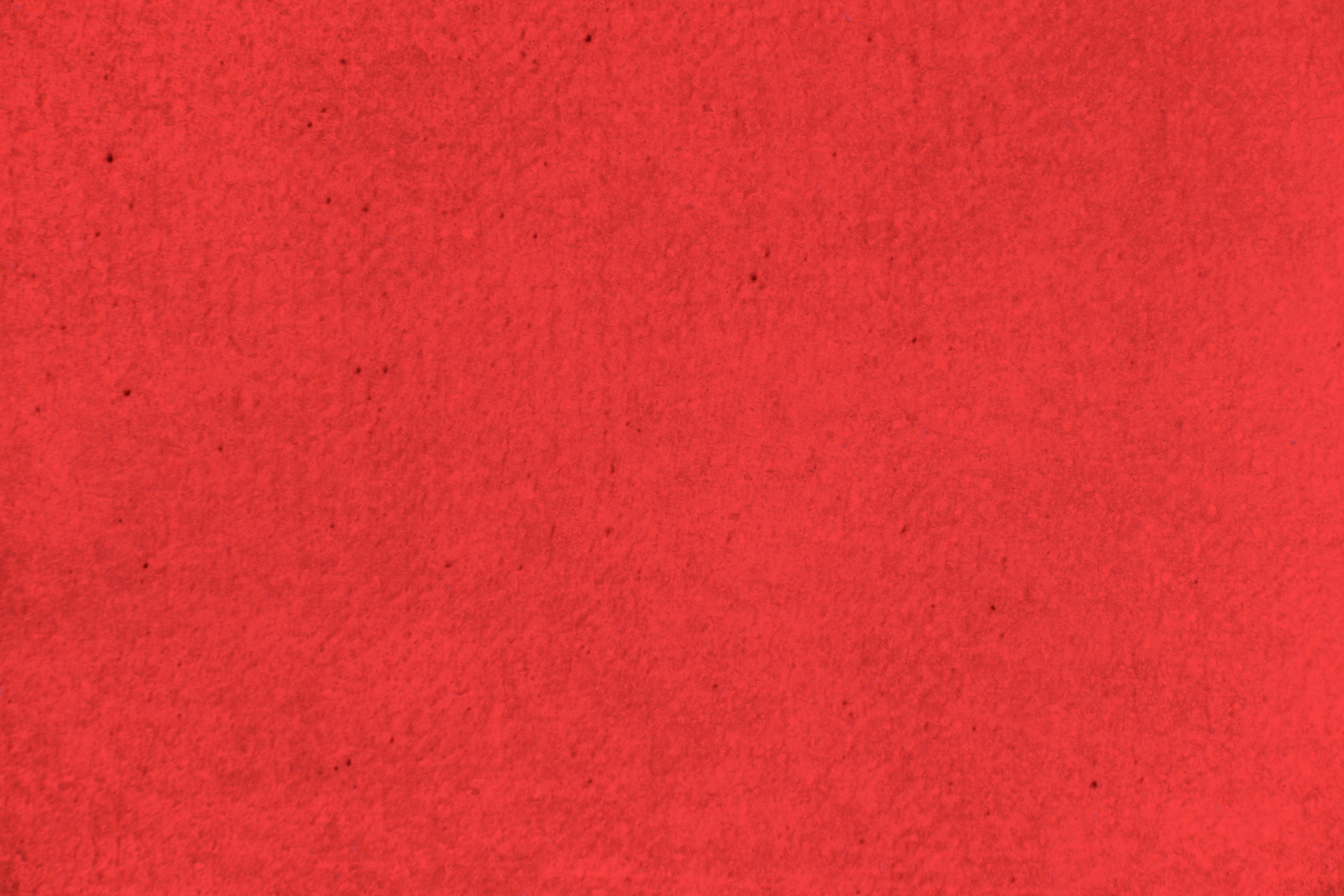 Solid red textured canvas with faint micro-grain and slight tonal variation; likely a studio color backdrop rather than a subject. Indicates a background or placeholder use in composition.