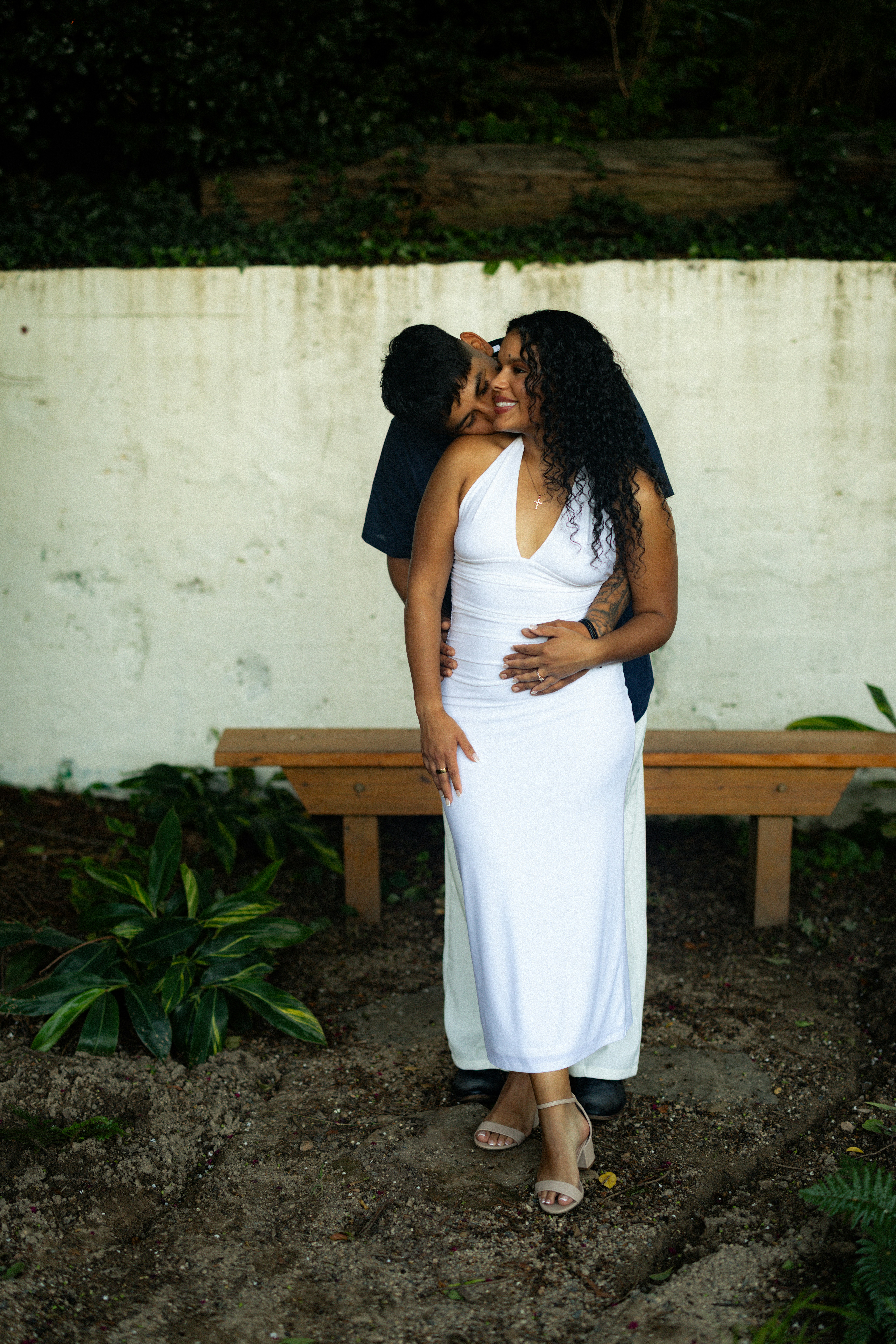 White-dressed embrace in a garden courtyard