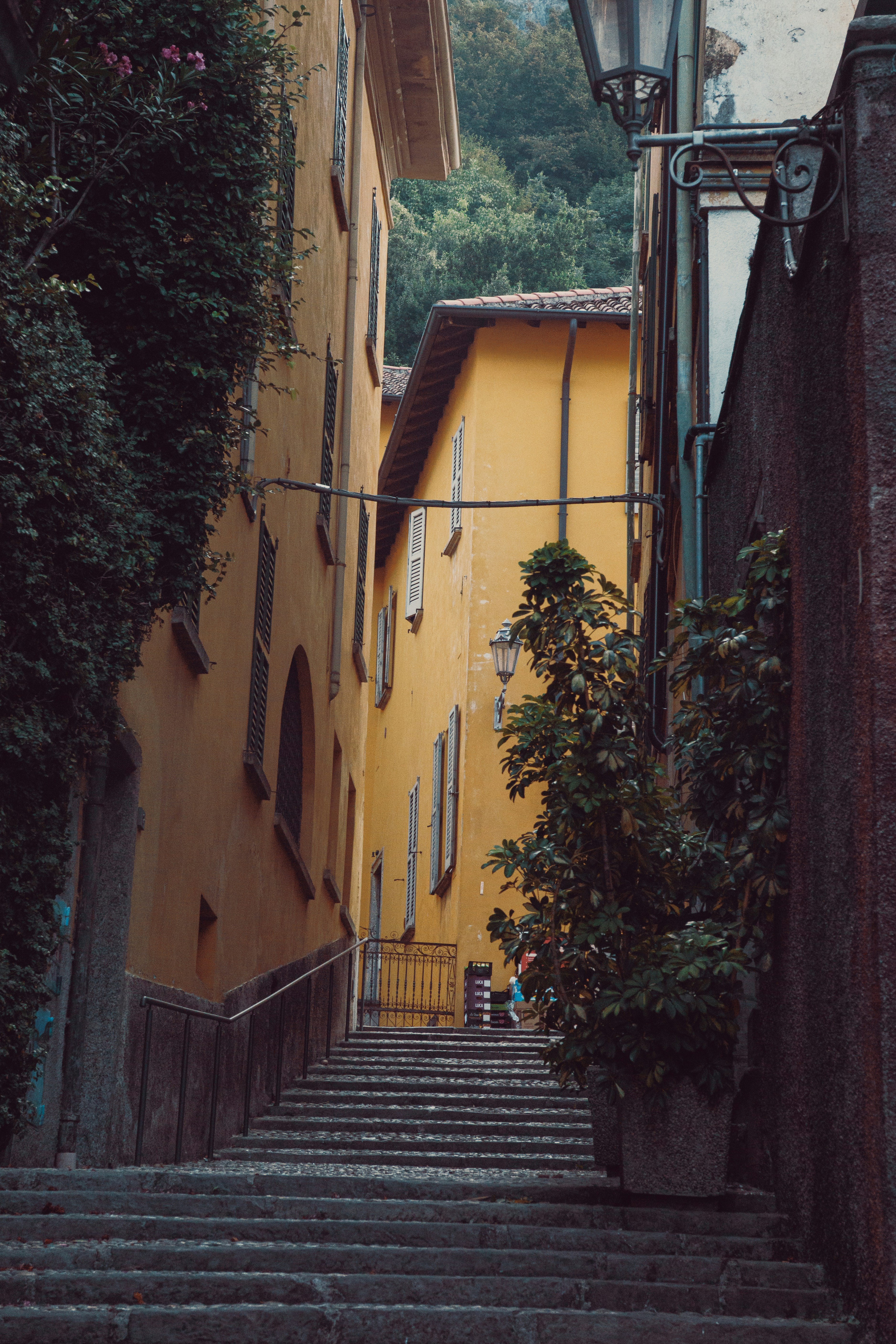 Yellow-walled alleyway ascent under hanging lamps
