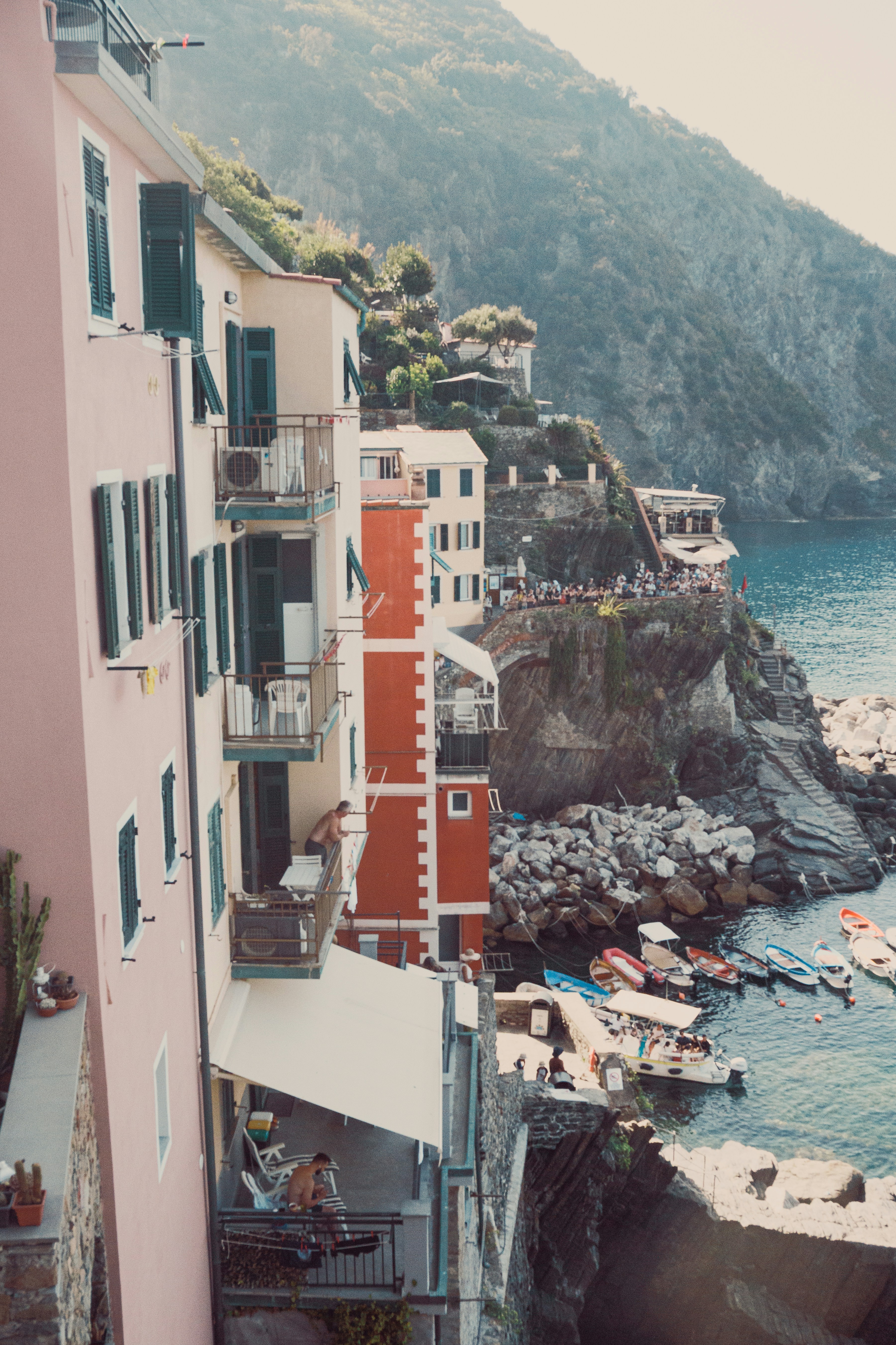 Colorful hillside apartments cling to the cliffs above a sunlit cove