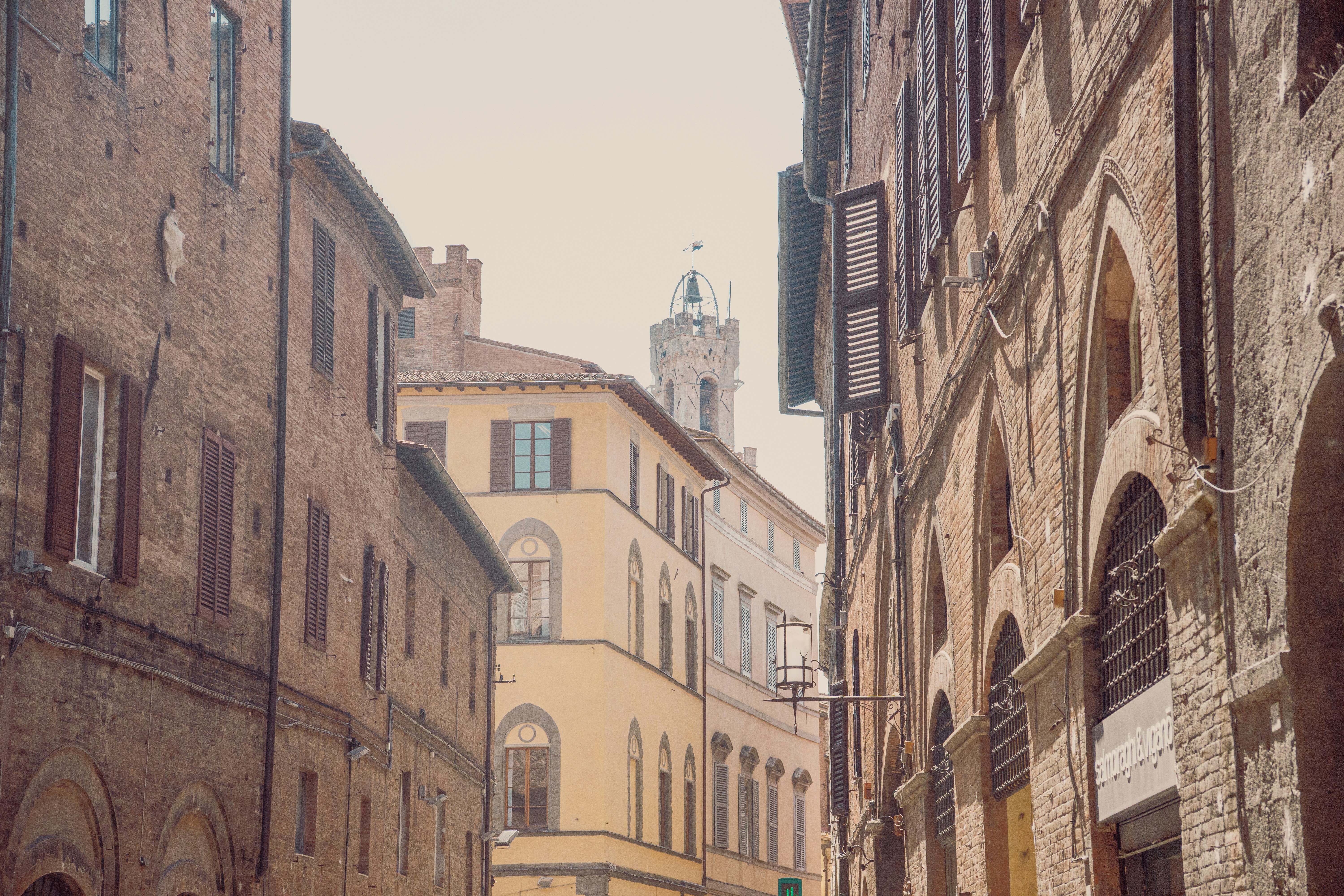 Sunlit Piazza Corridor Between Historic Brick Facades
