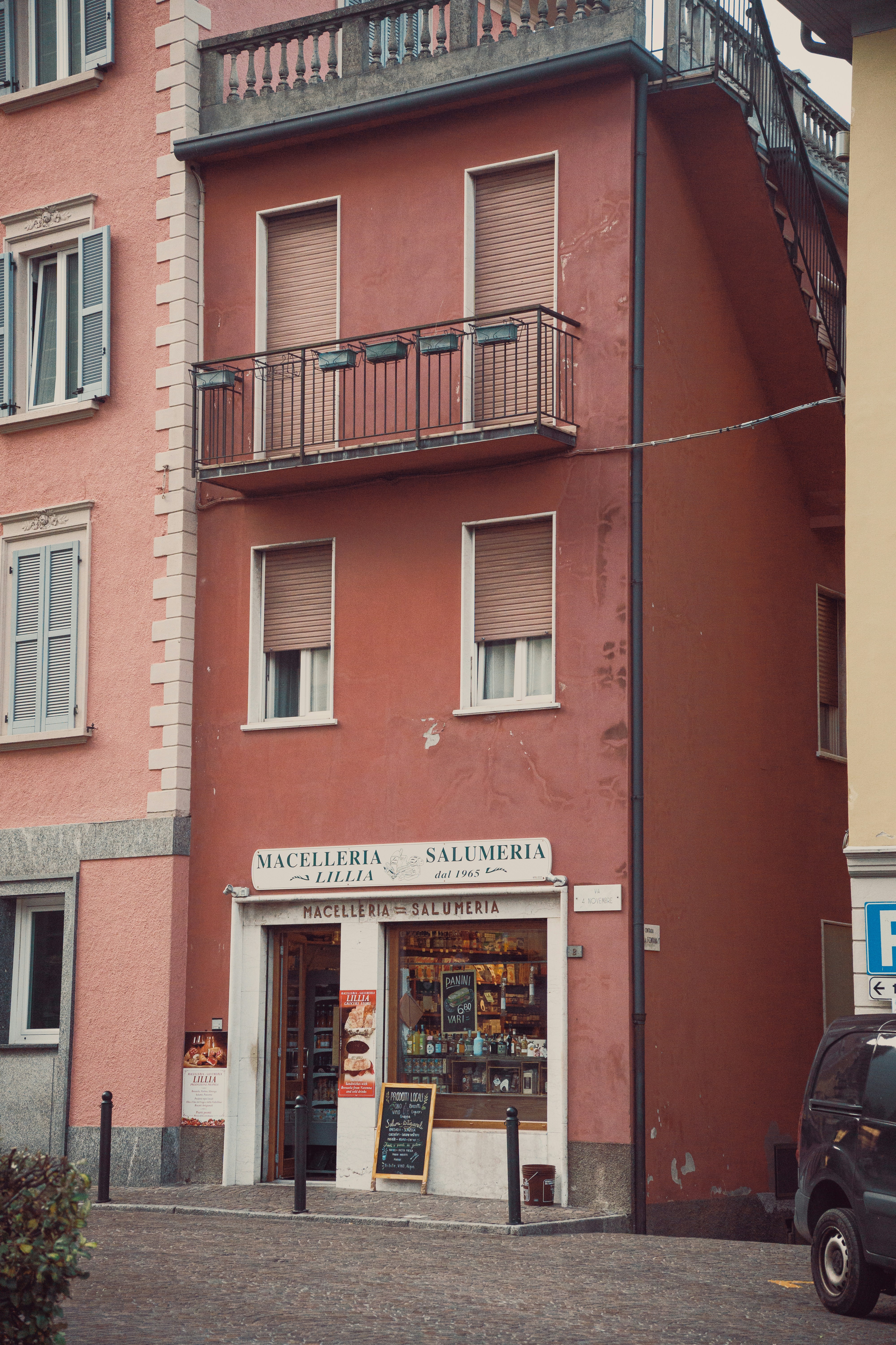 Sunlit Red Facade and Ground-Level Bistro in a Quiet European Street