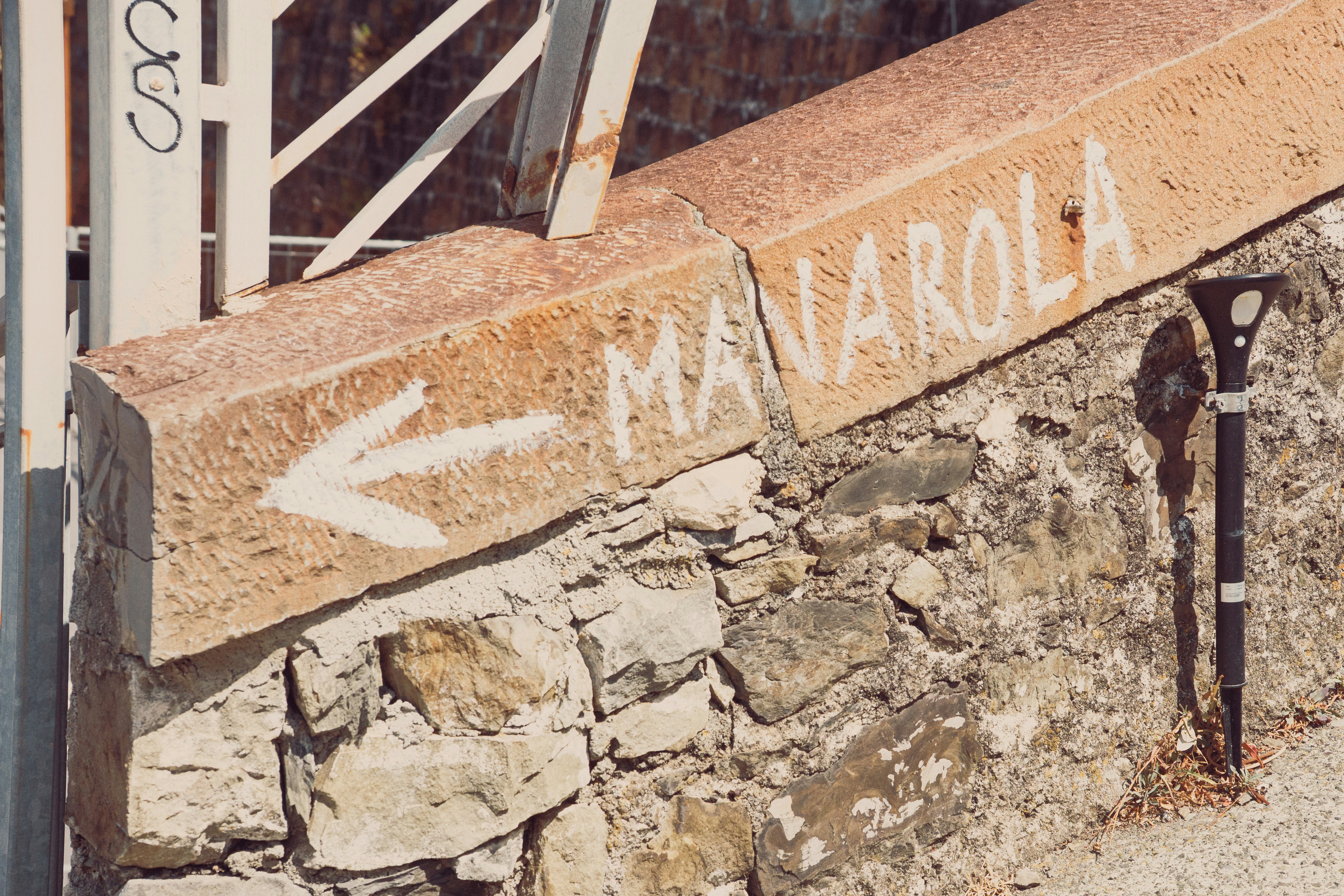  chalky stone with white arrow and inscription along a sunlit path