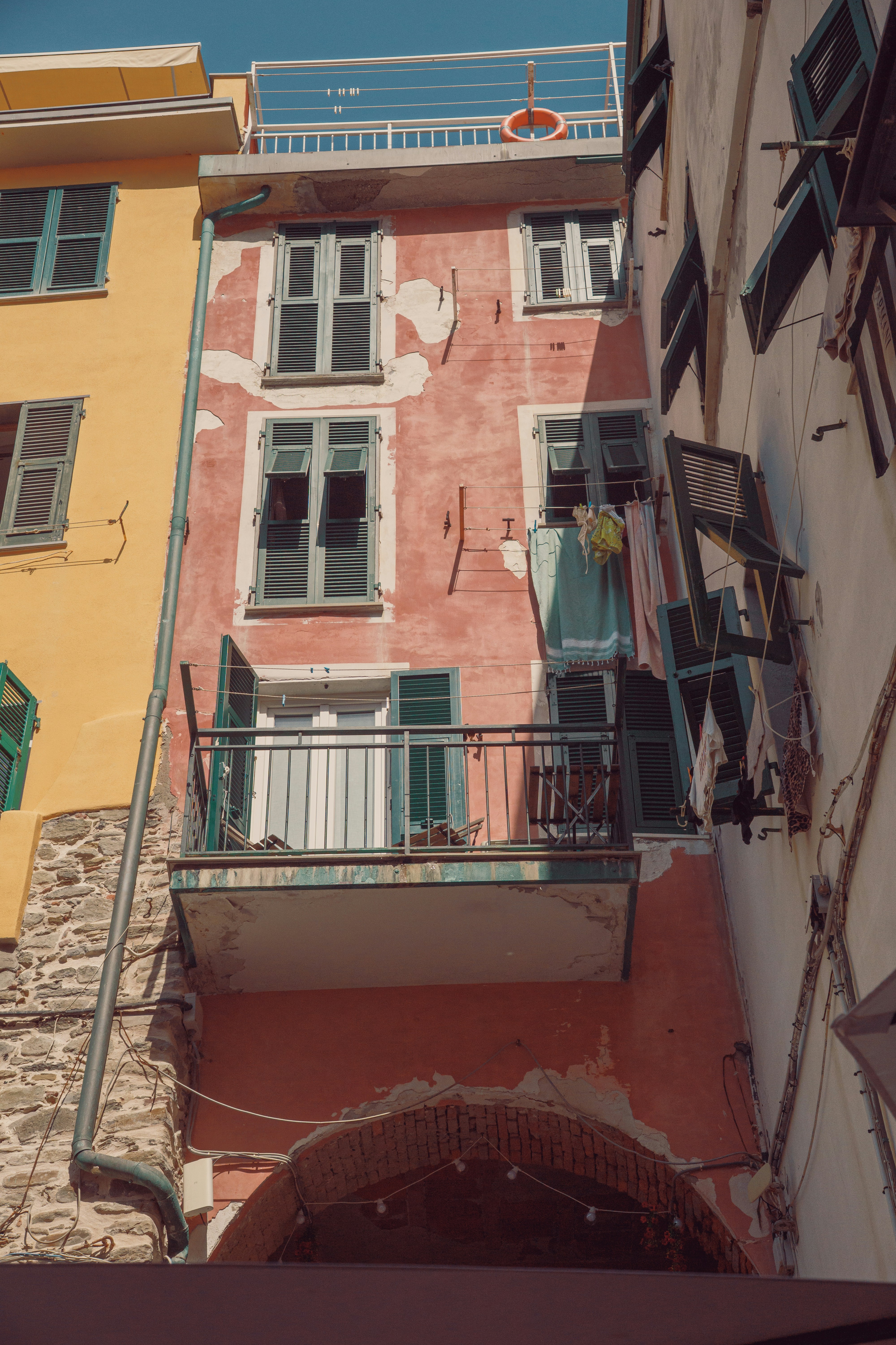 Sunlit Pink Facade: A Colorful Urban Courtyard Portrait