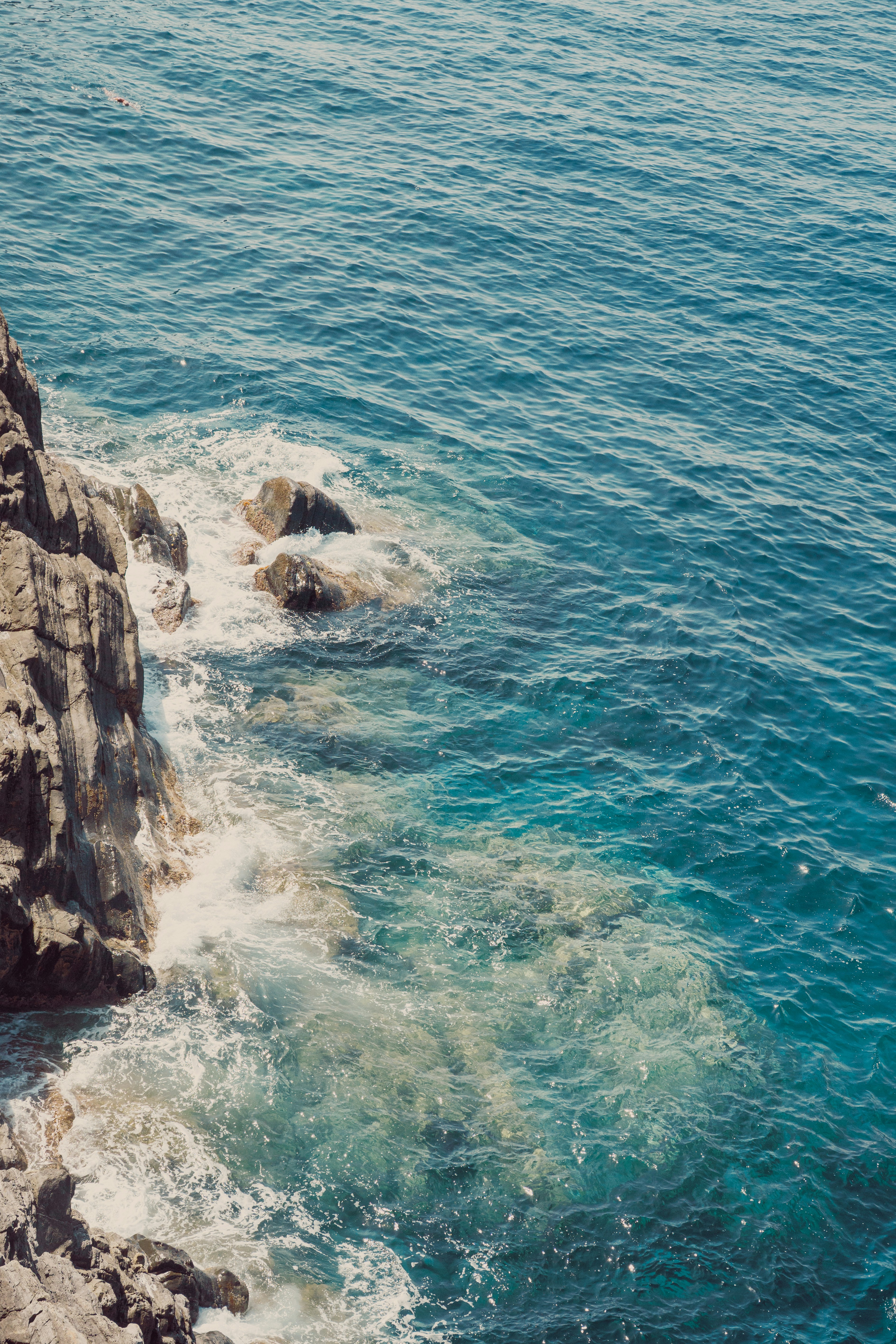 Cliffside Pulse: Sunlit Cape Meeting the Deep Blue