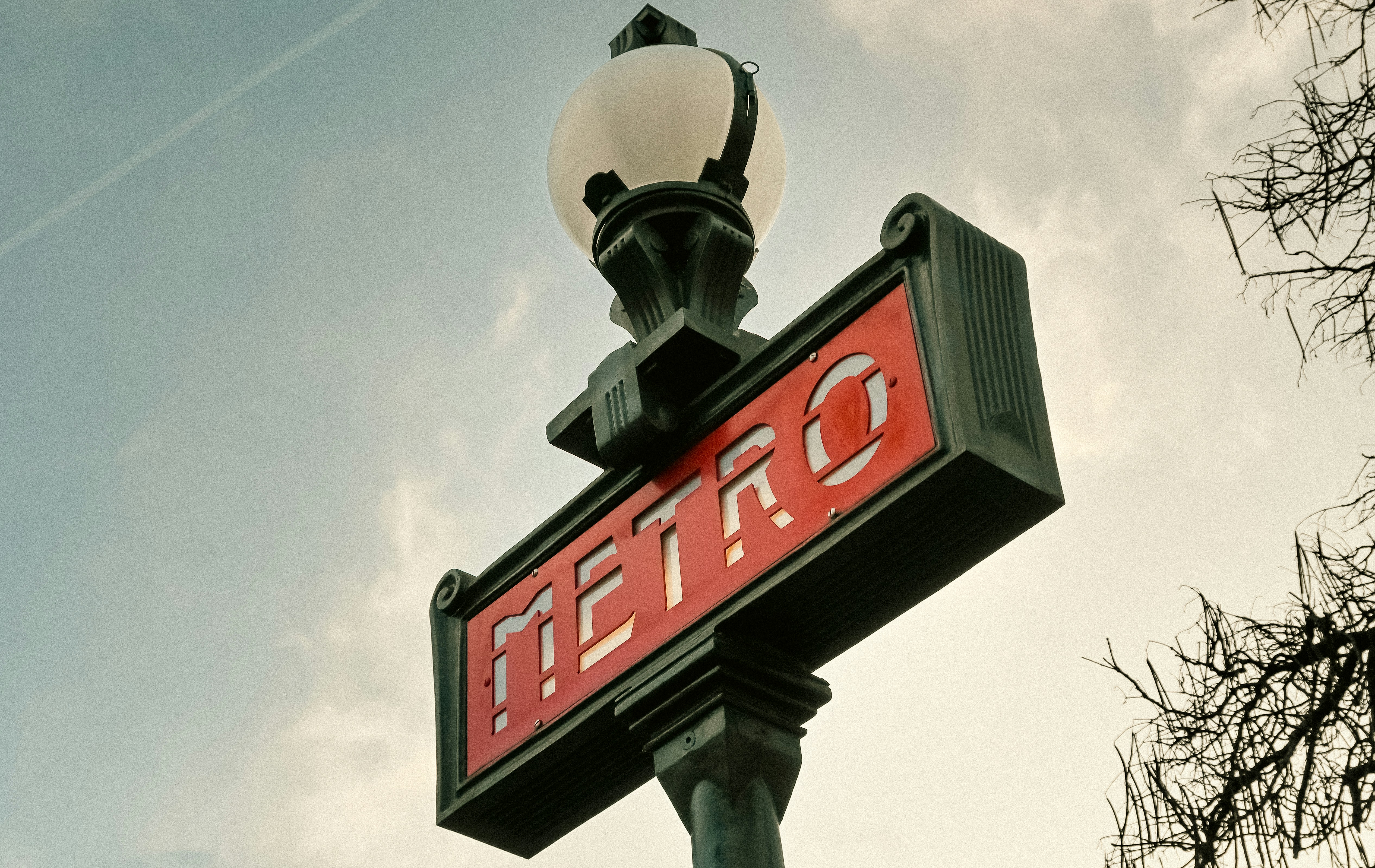 Metro Sign: A Retro Lantern Against a Quiet Sky