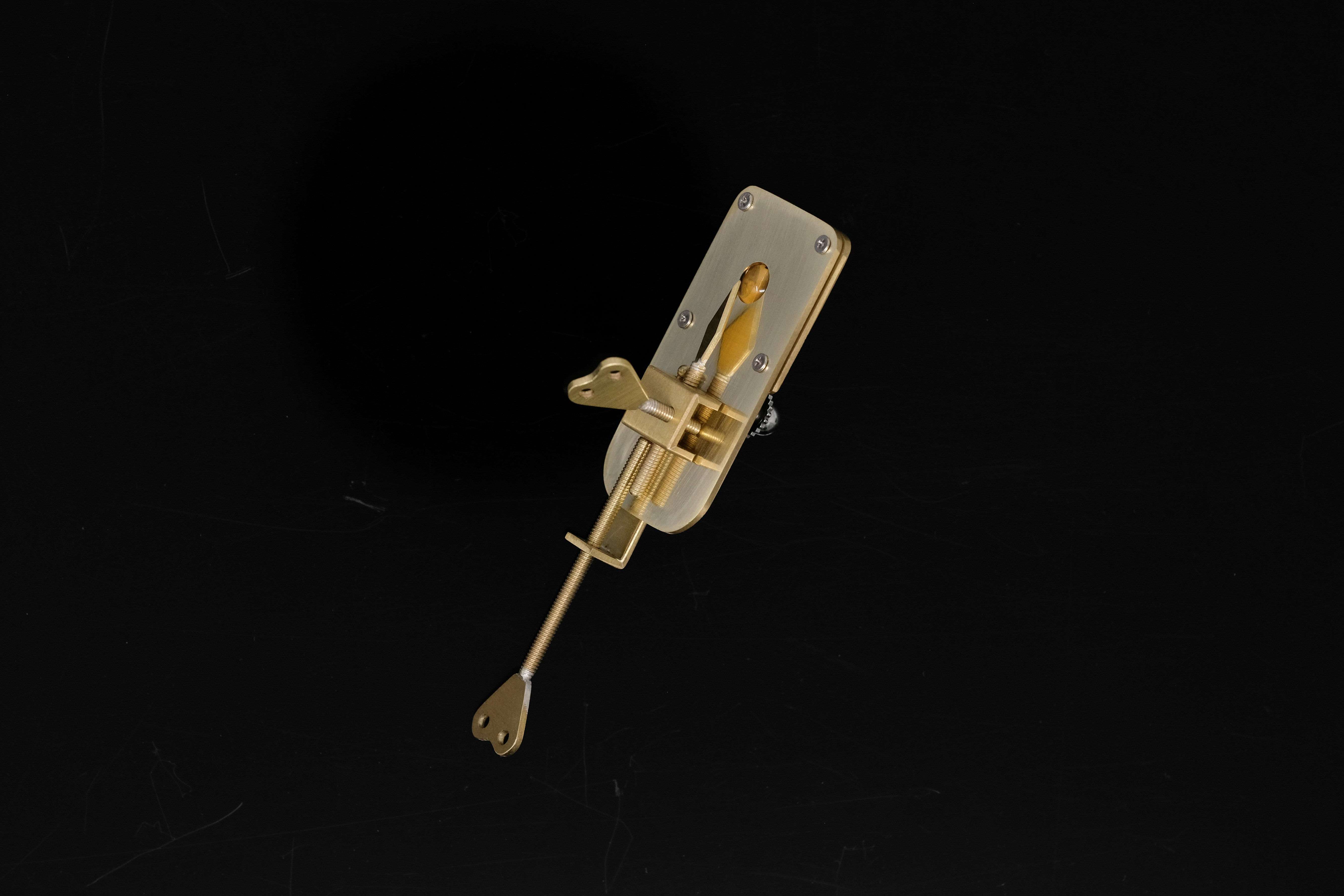 Golden mechanical actuator on a stark black stage