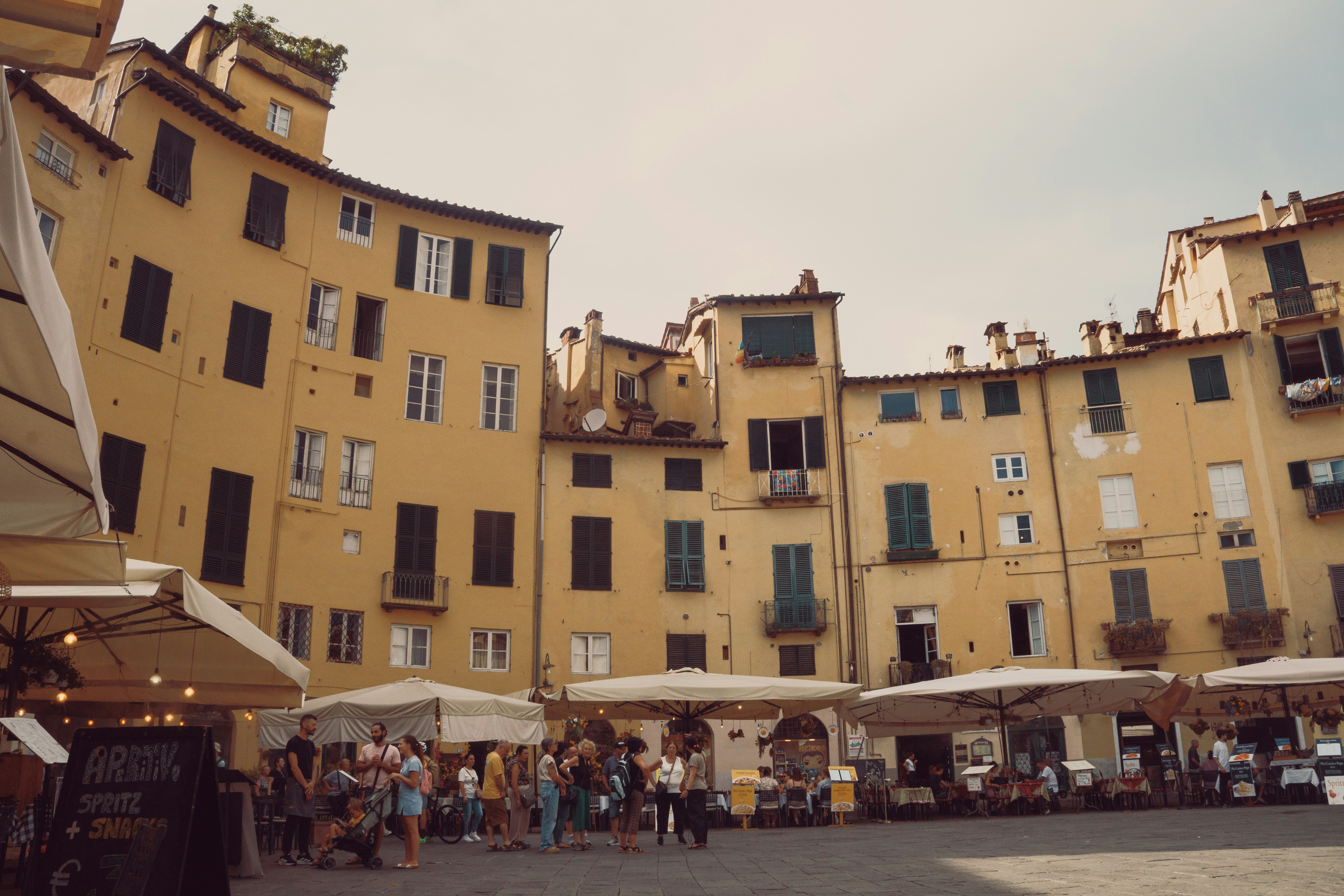 Café Terrace beneath sunlit ochre facades in a sunlit square