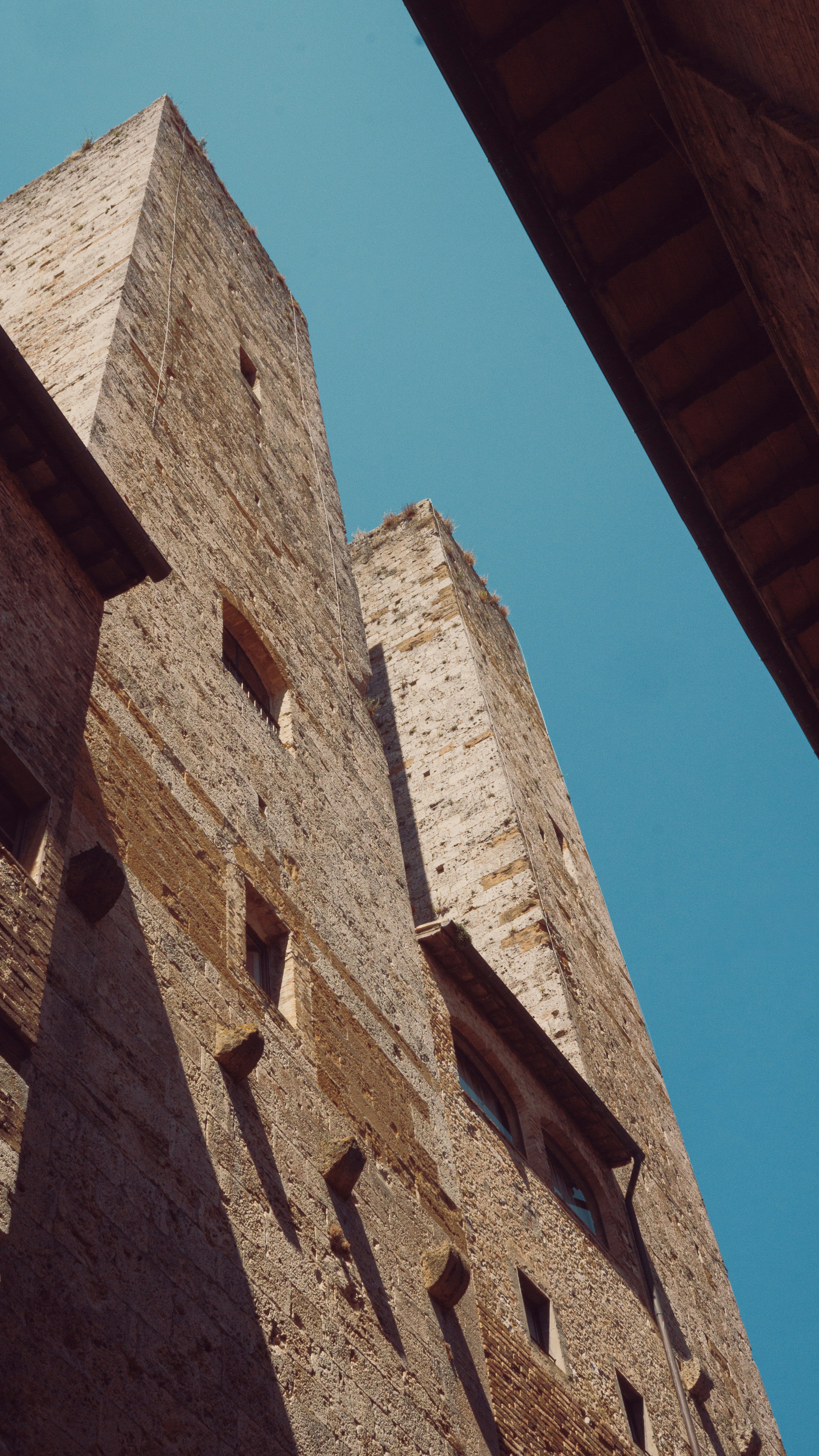 Upward Gaze at a Medieval Facade under a Clear Blue Sky