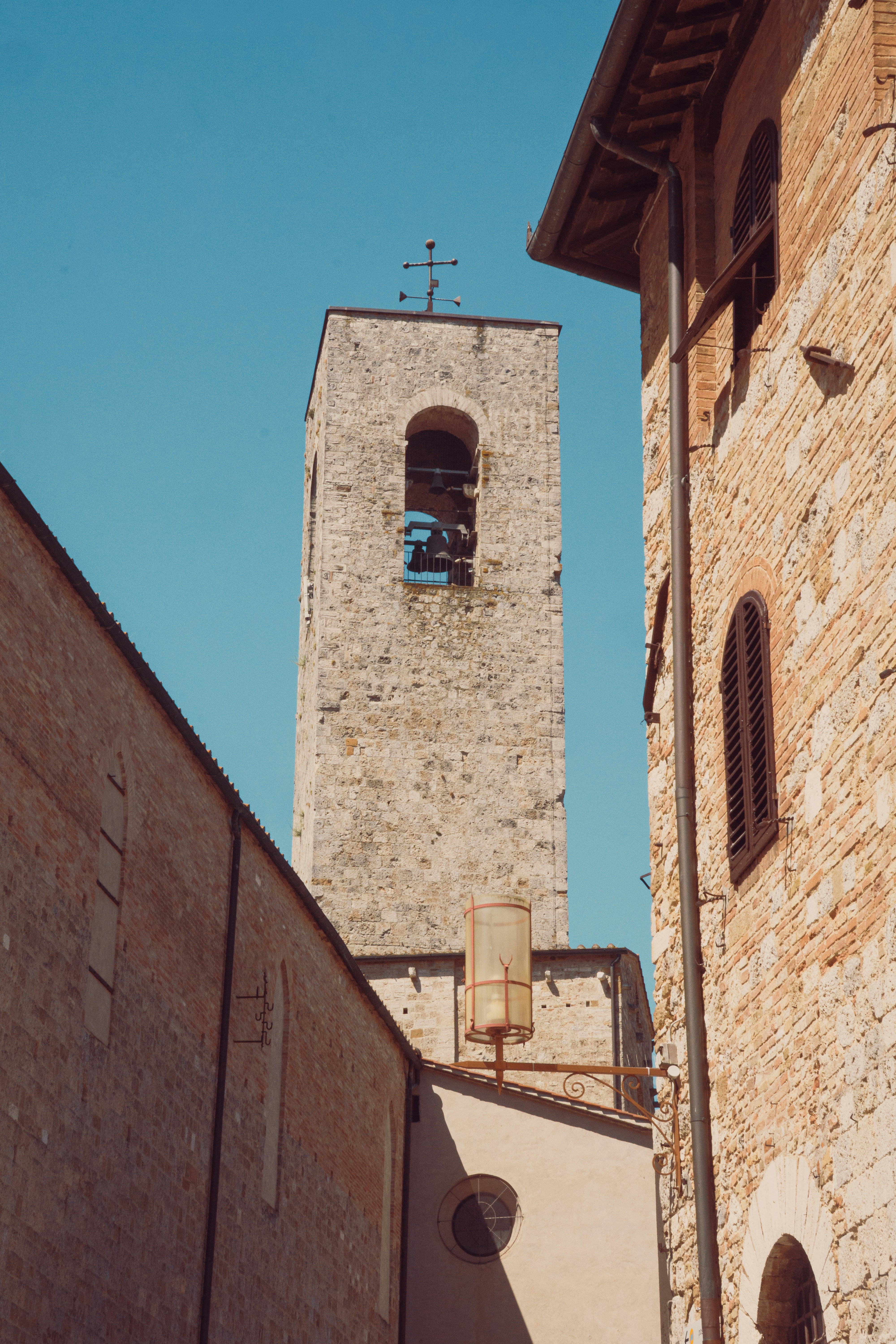 Towering Bell Tower Framed Between Rustic Walls