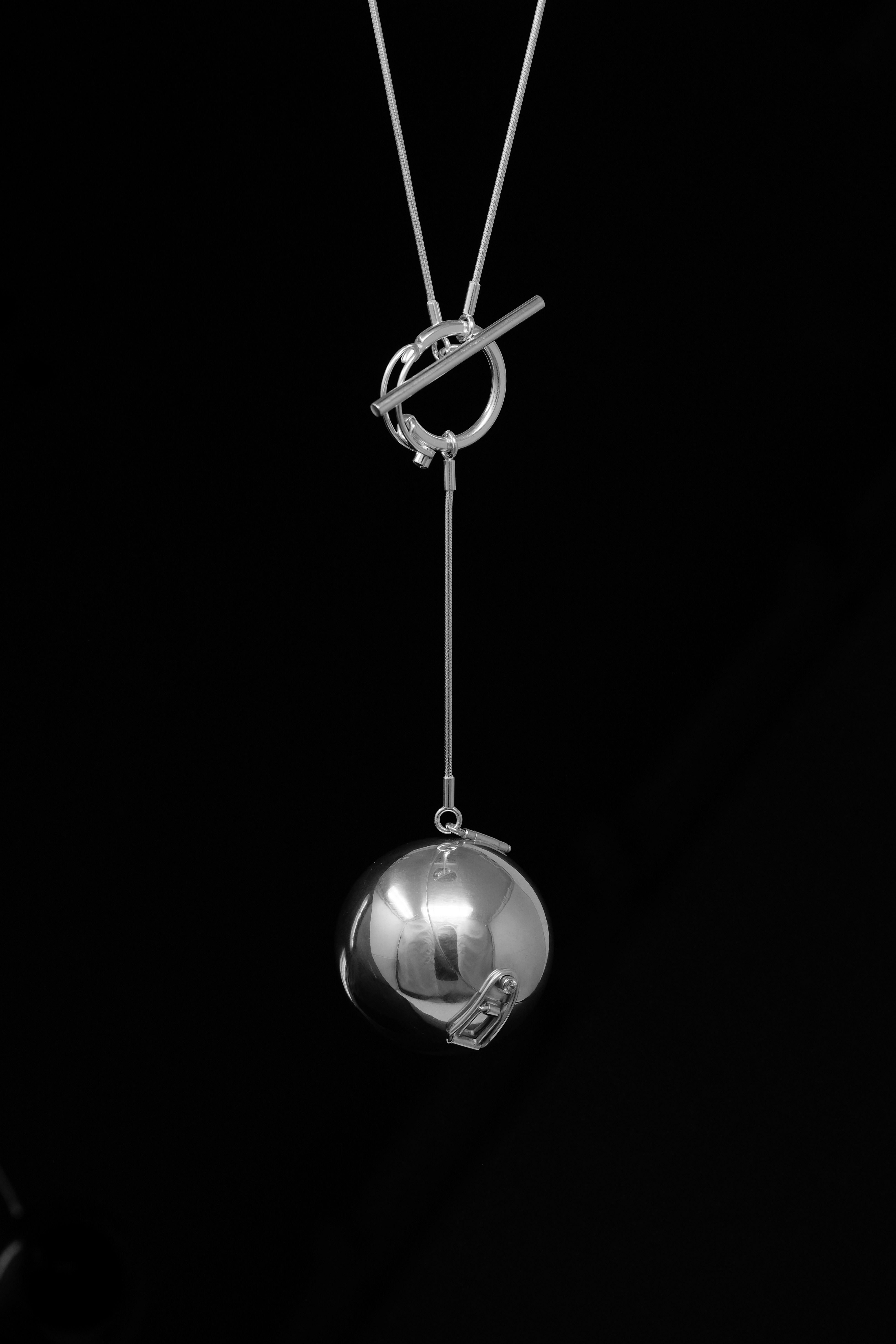 Suspended Sphere: A Gleaming Pendant in stark noir