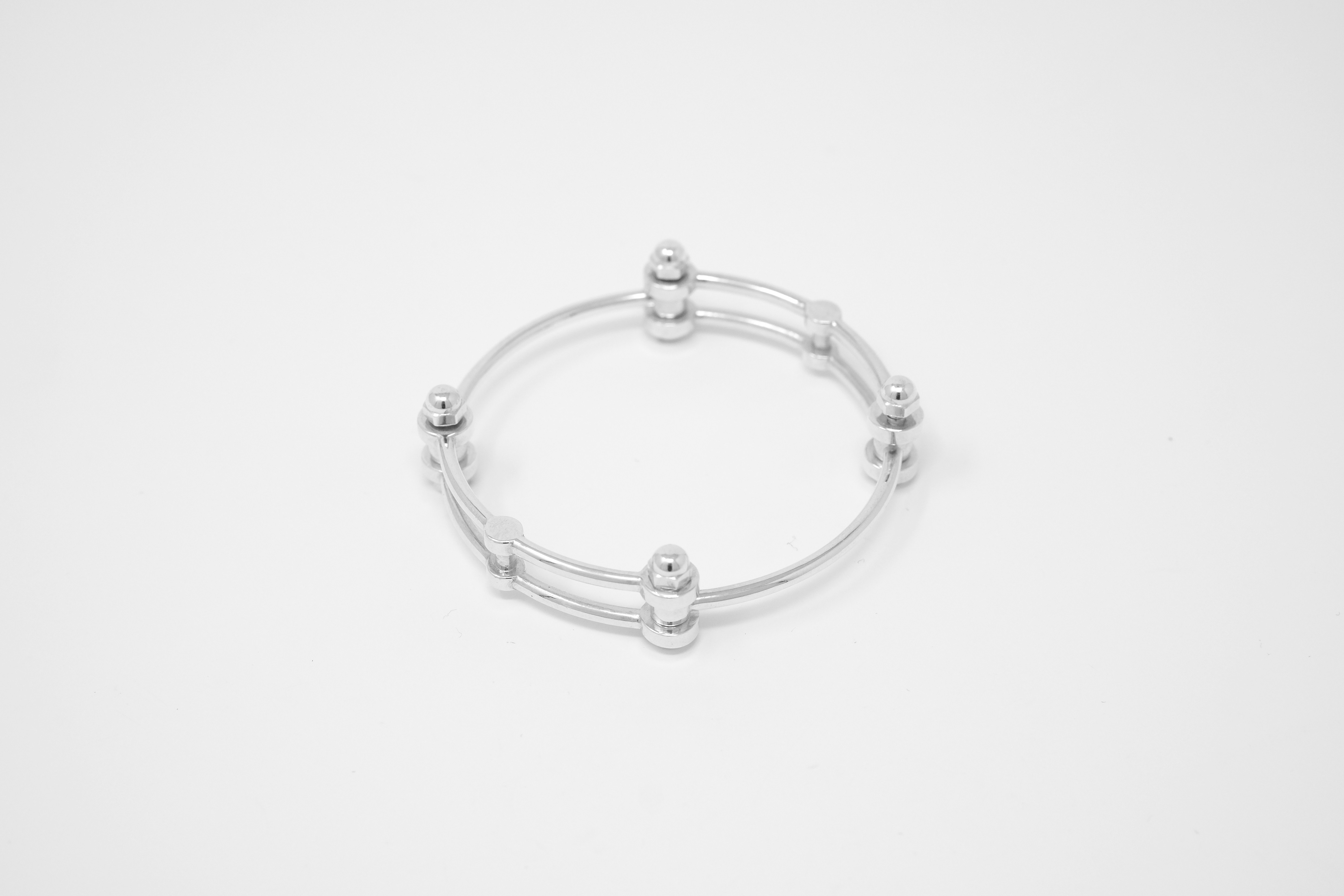 Circular Silver Ring with Bead Accents resting on a clean white surface