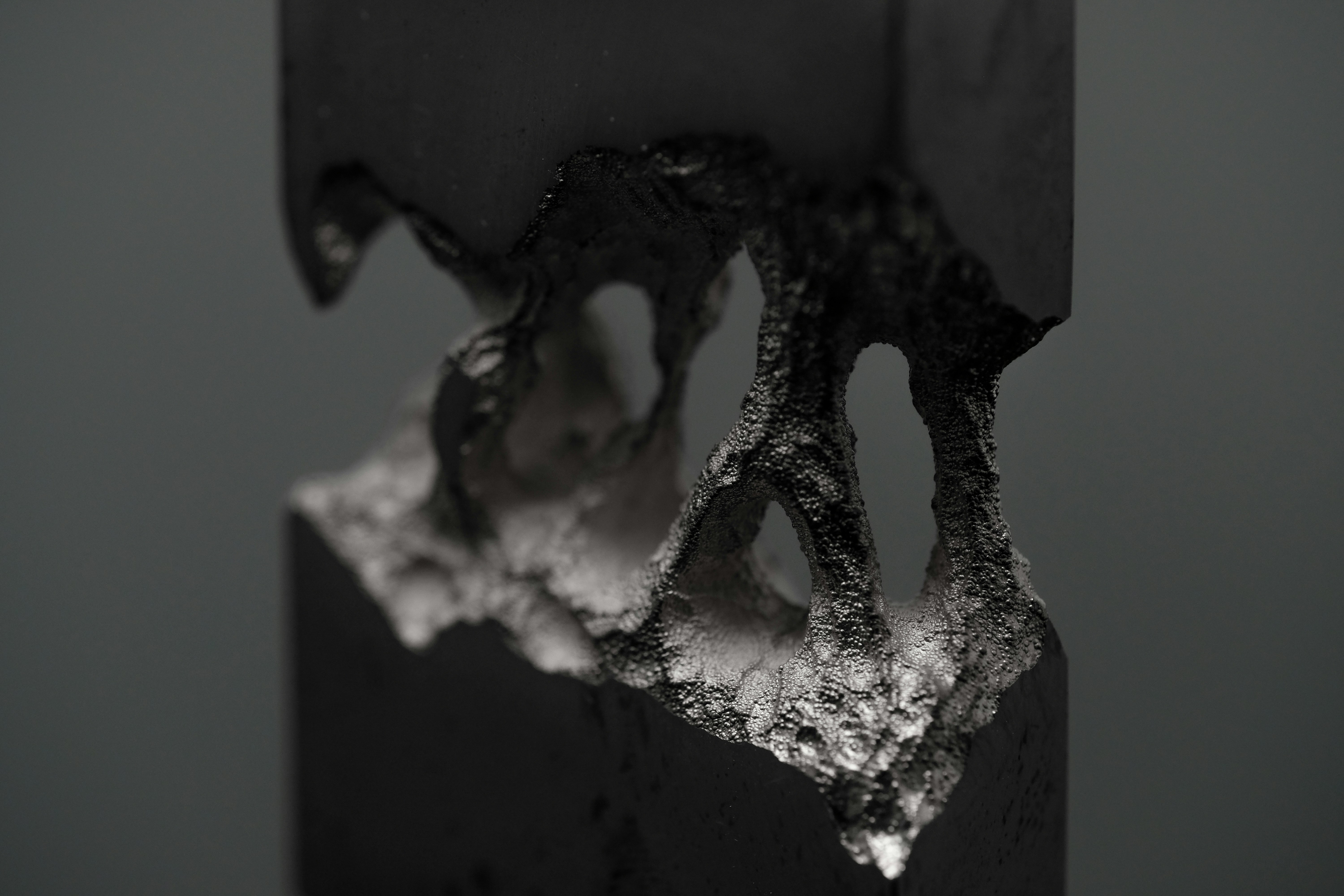 Charred Void: A Close-Up of Fractured Steel and Ash