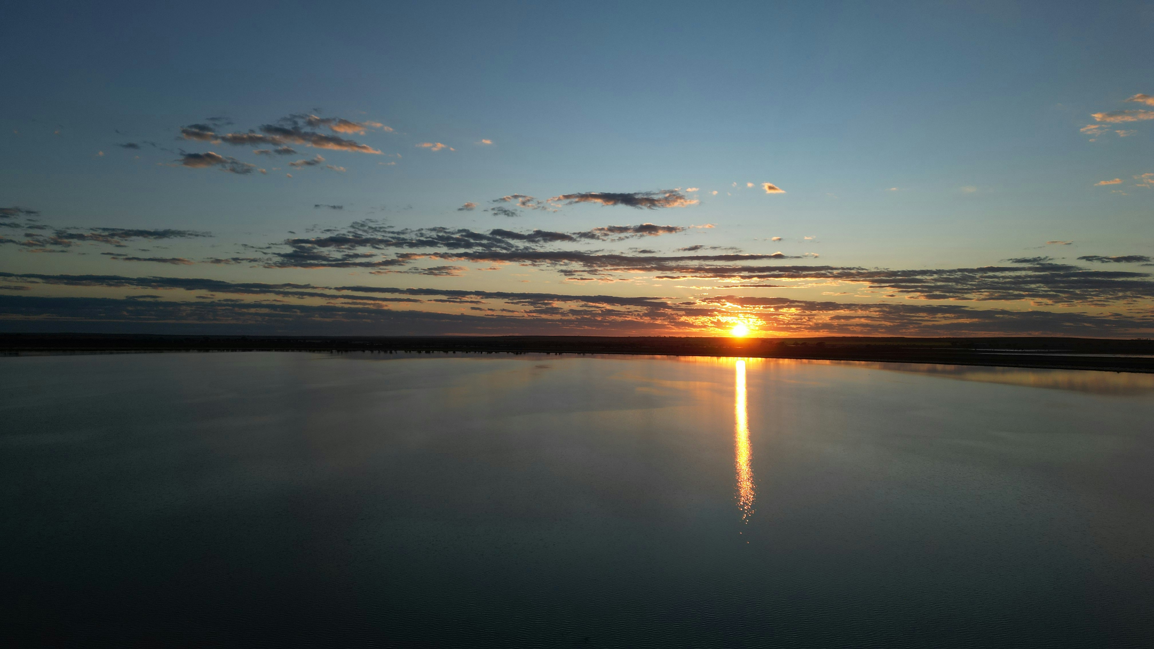 Sunlit Horizon Over Quiet Inland Waters