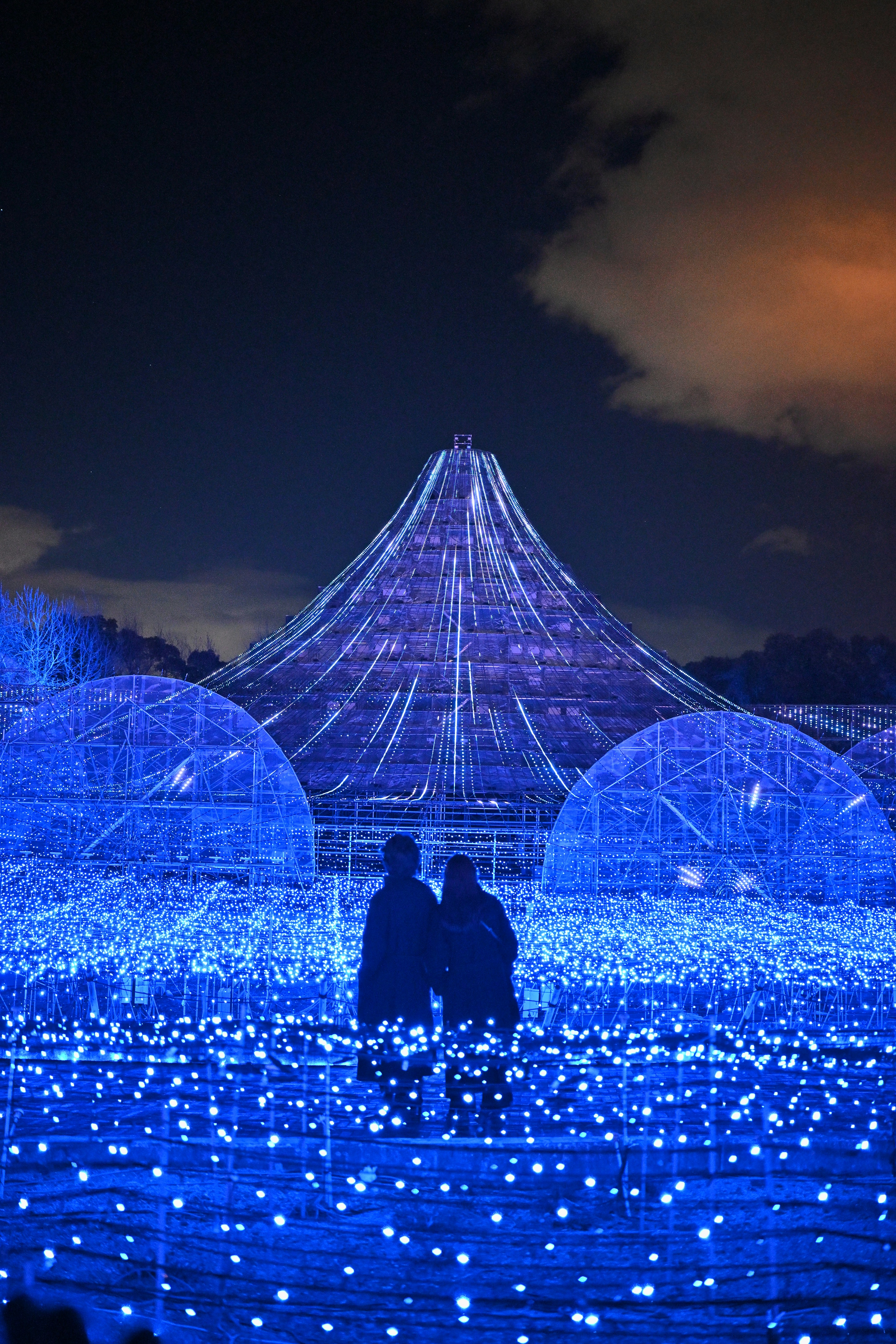 Blue Luminescence: A Couple in the Glow of a Nighttime Light Dome