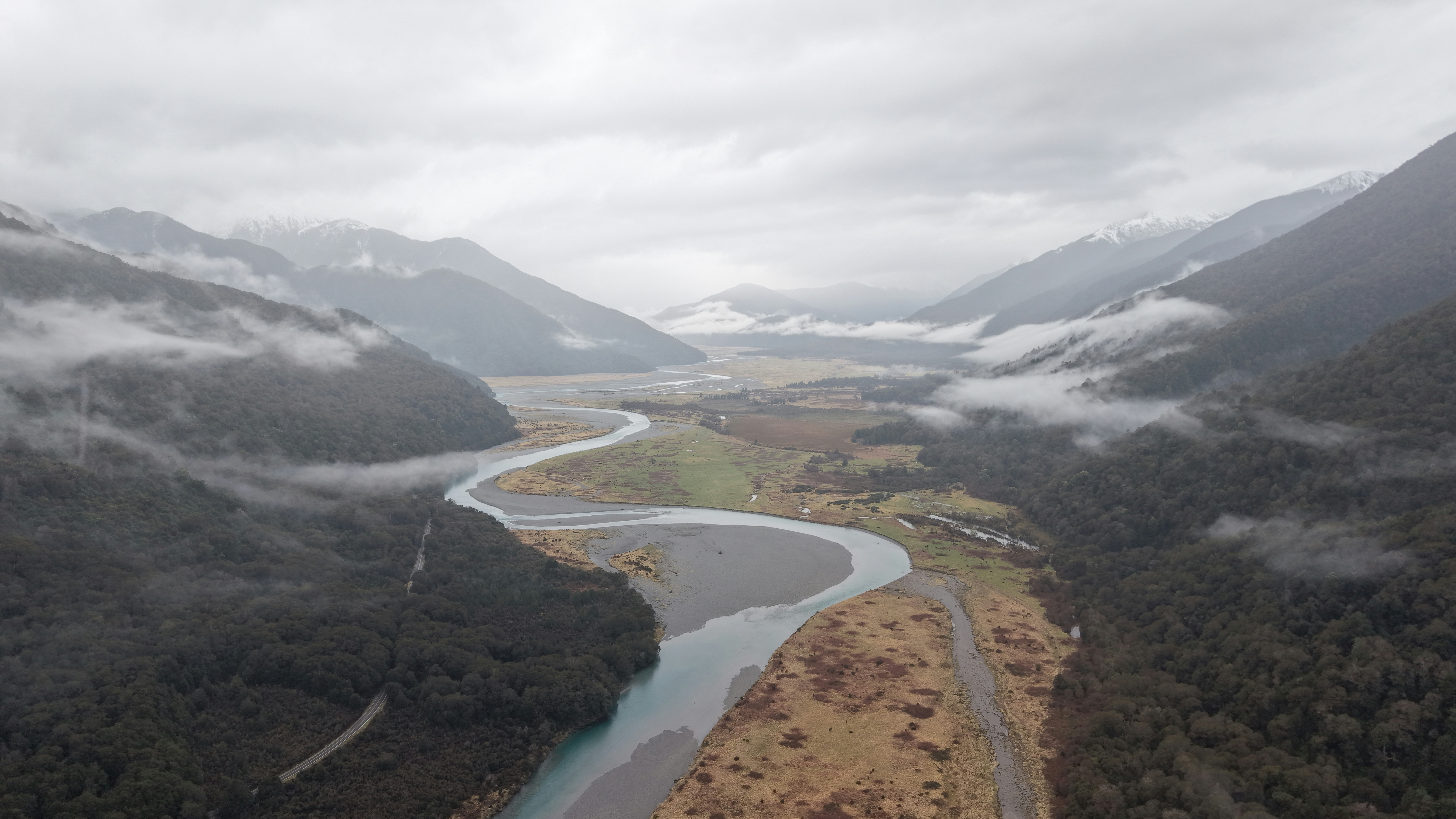 Serpentine River Valley Carving Through Misted Valleys