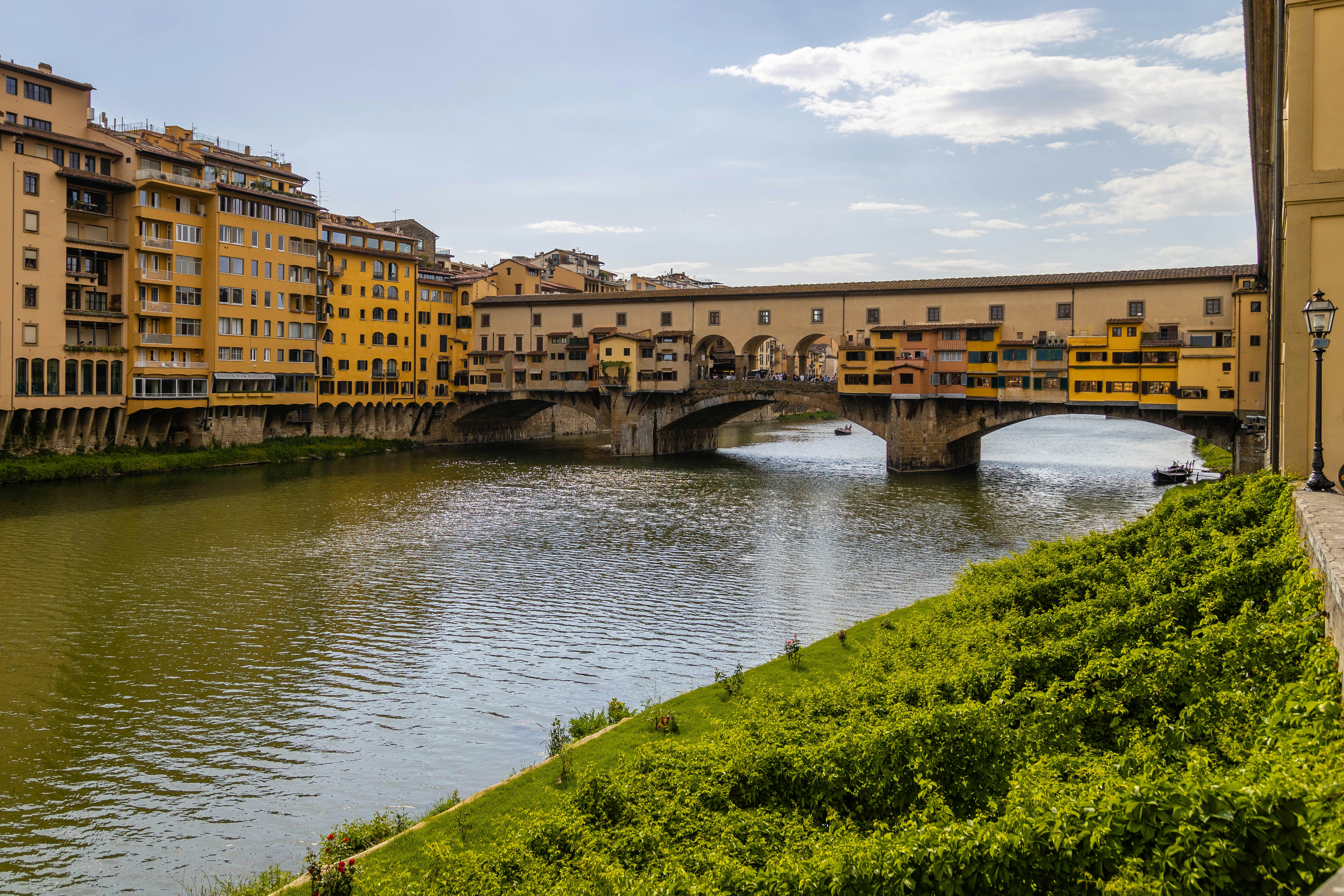 Florentine Riverwork: The Ponte Vecchio–style Bridge Framed by a Tea-Colored Waterway