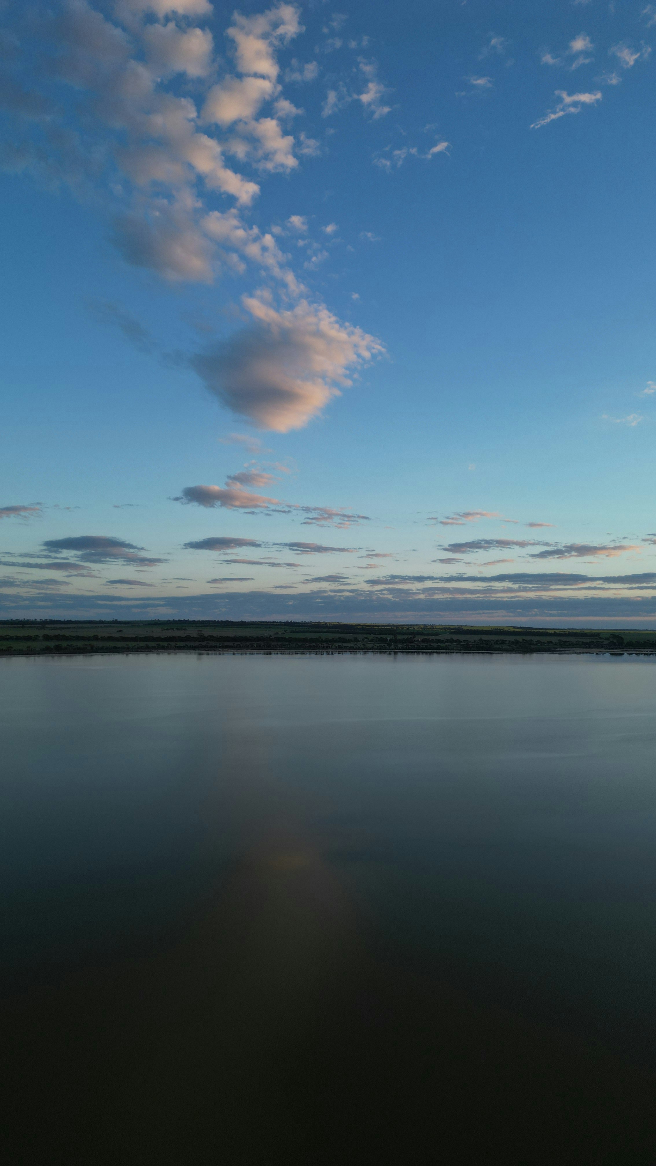 Azure Horizon: Tranquil Water and Sky Reflect in Quiet Dusk