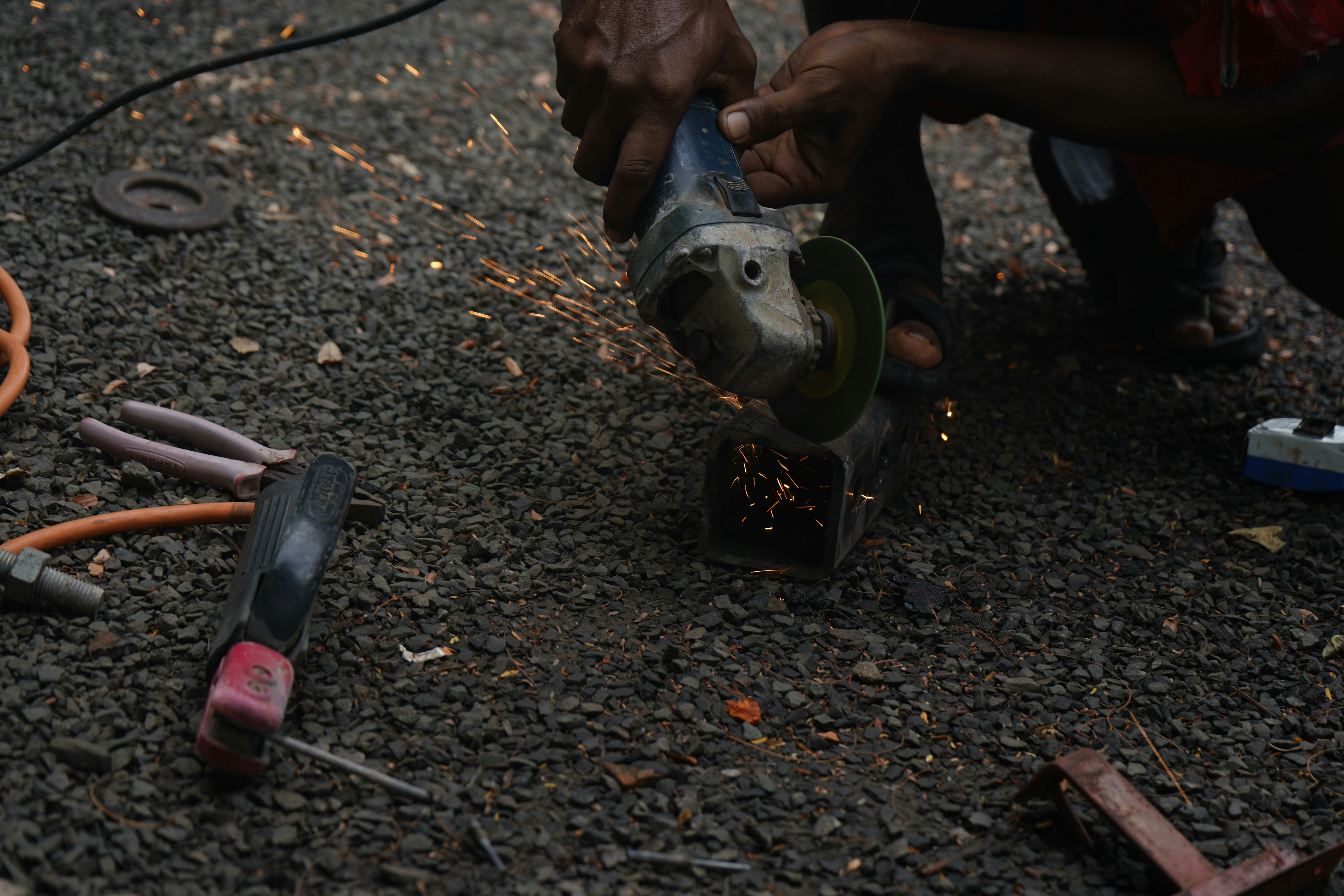 Sparks and Steel: Hands Guiding a Grinder in a Rough Corner