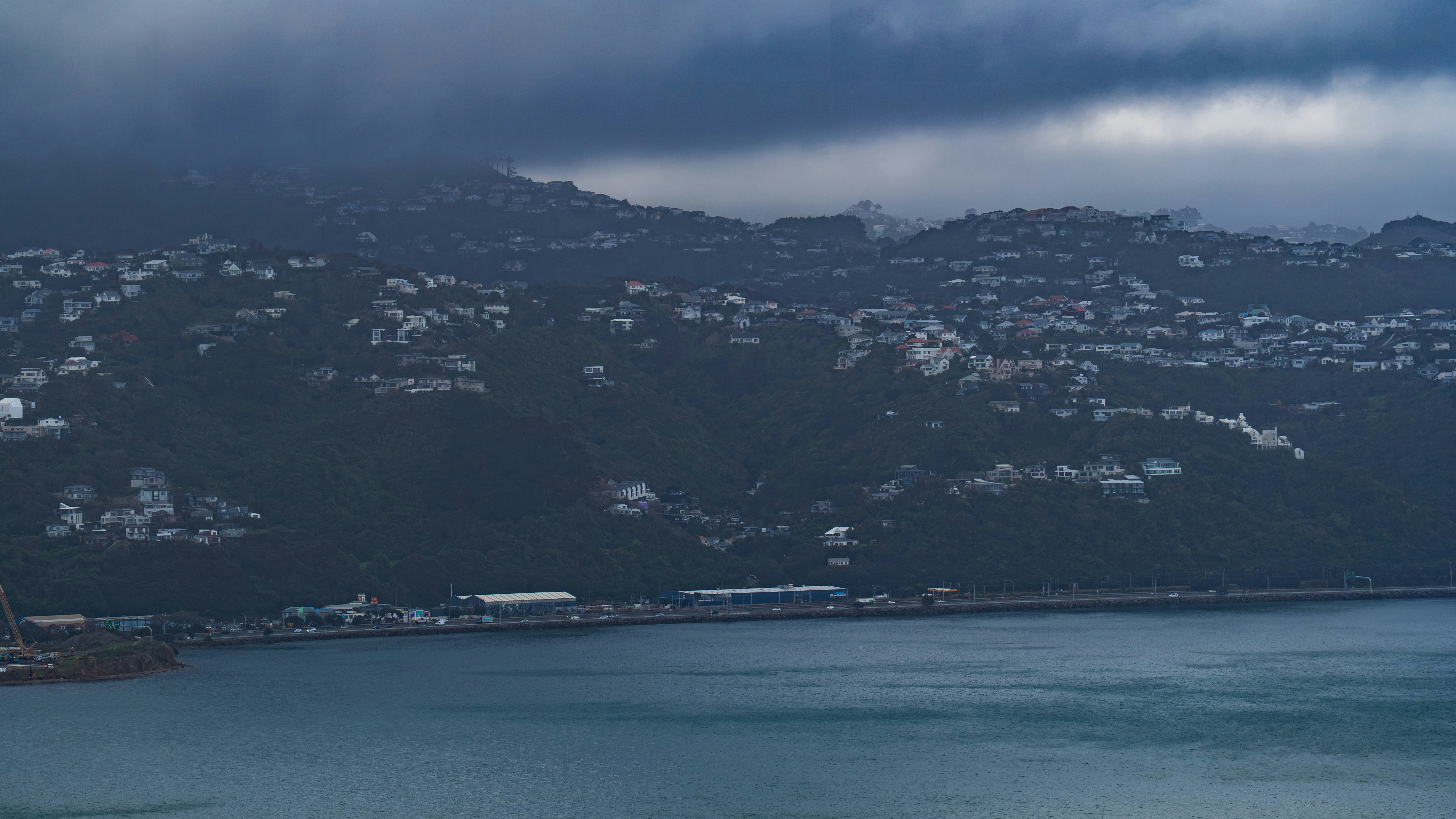Coastal hillside village under stormy skies