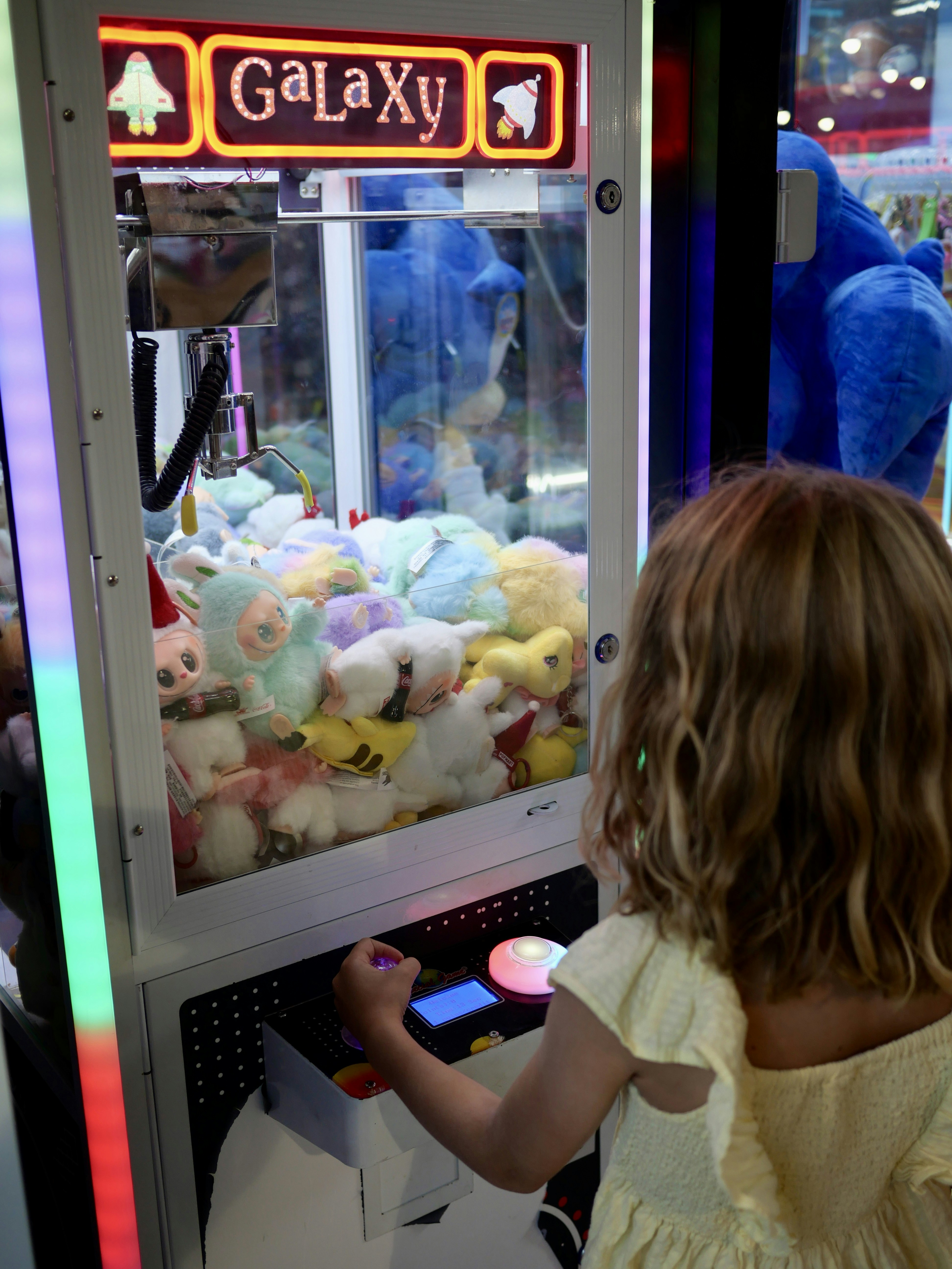 Soft Toy Heist: A Girl Plays Claw in Neon Candy Shop