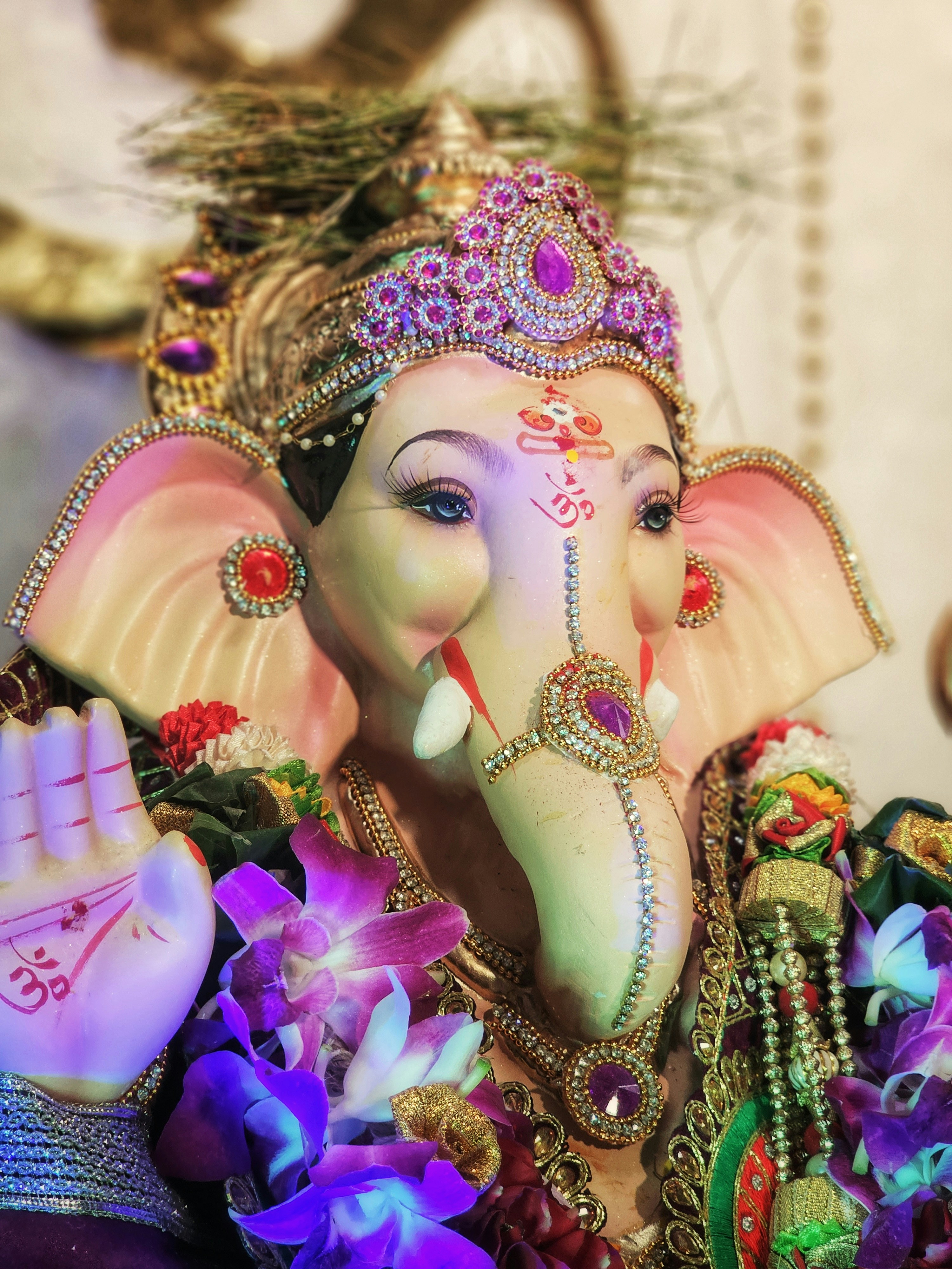 Regal Ganesha: Adorned with jewels amid a burst of color and ritual flowers