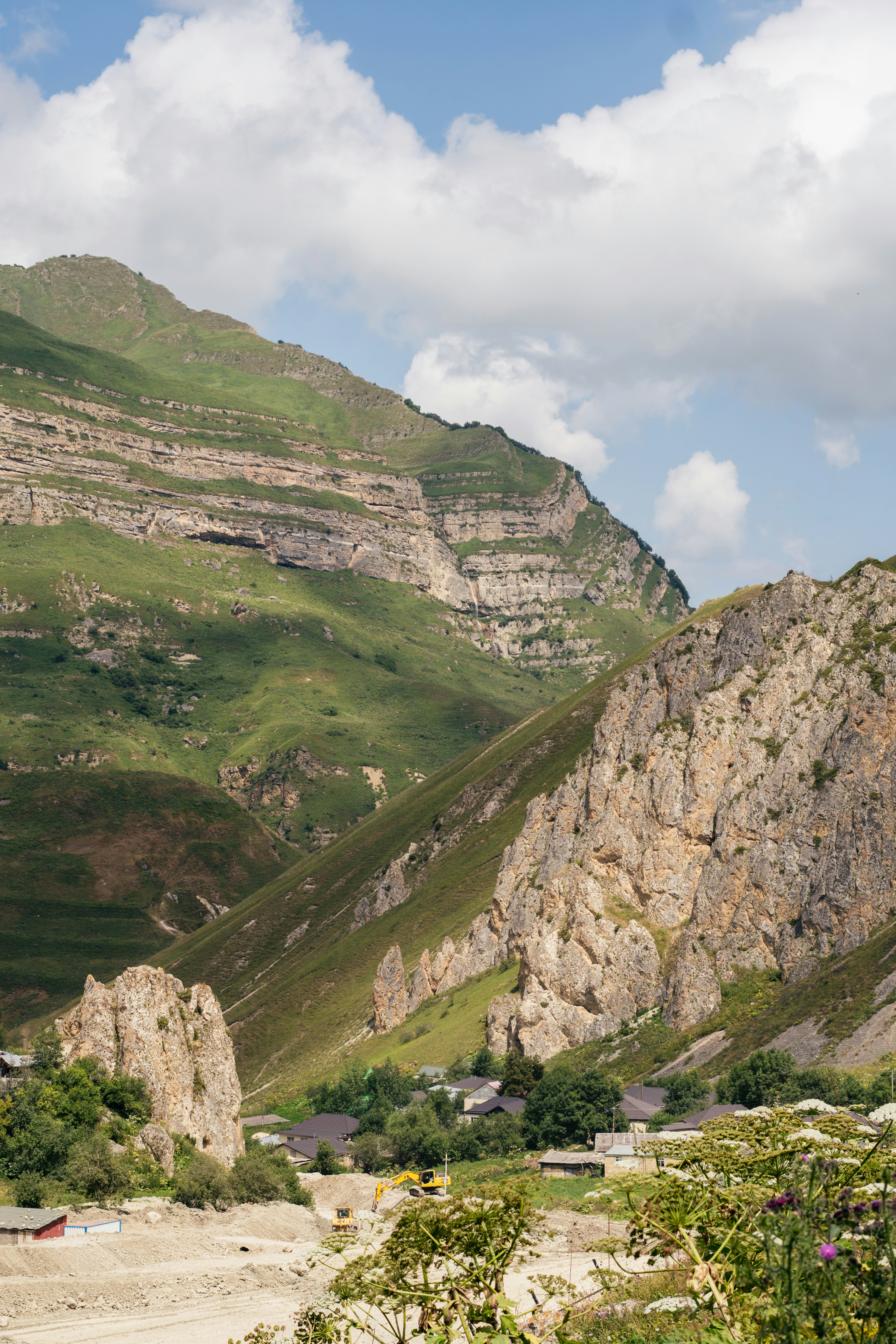 Valley Edge: Green Slopes and Rocky Cliffs Meeting Under a Flight of Clouds