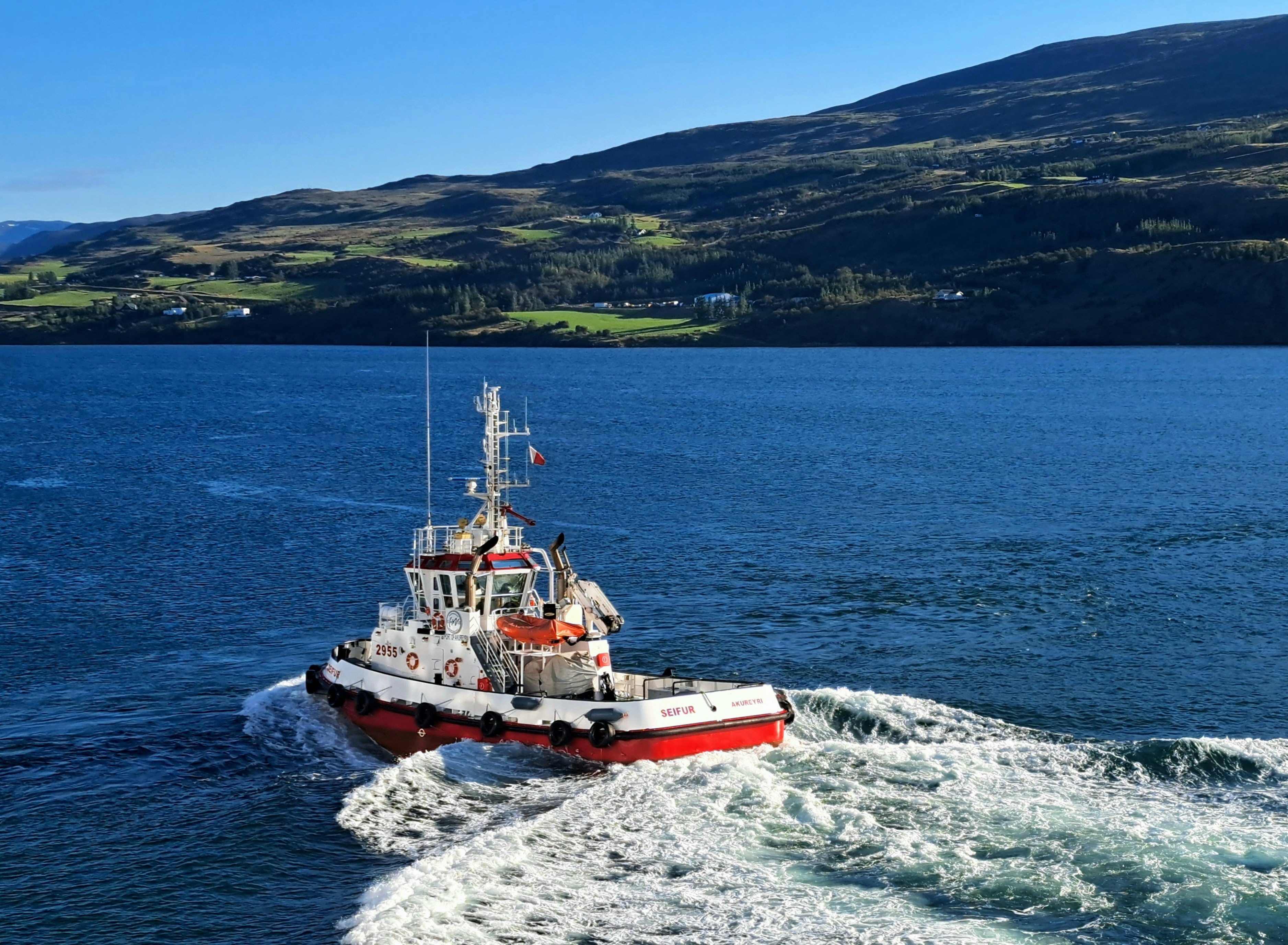 Tugboat Cutting Through Blue Waters Toward the Inlet