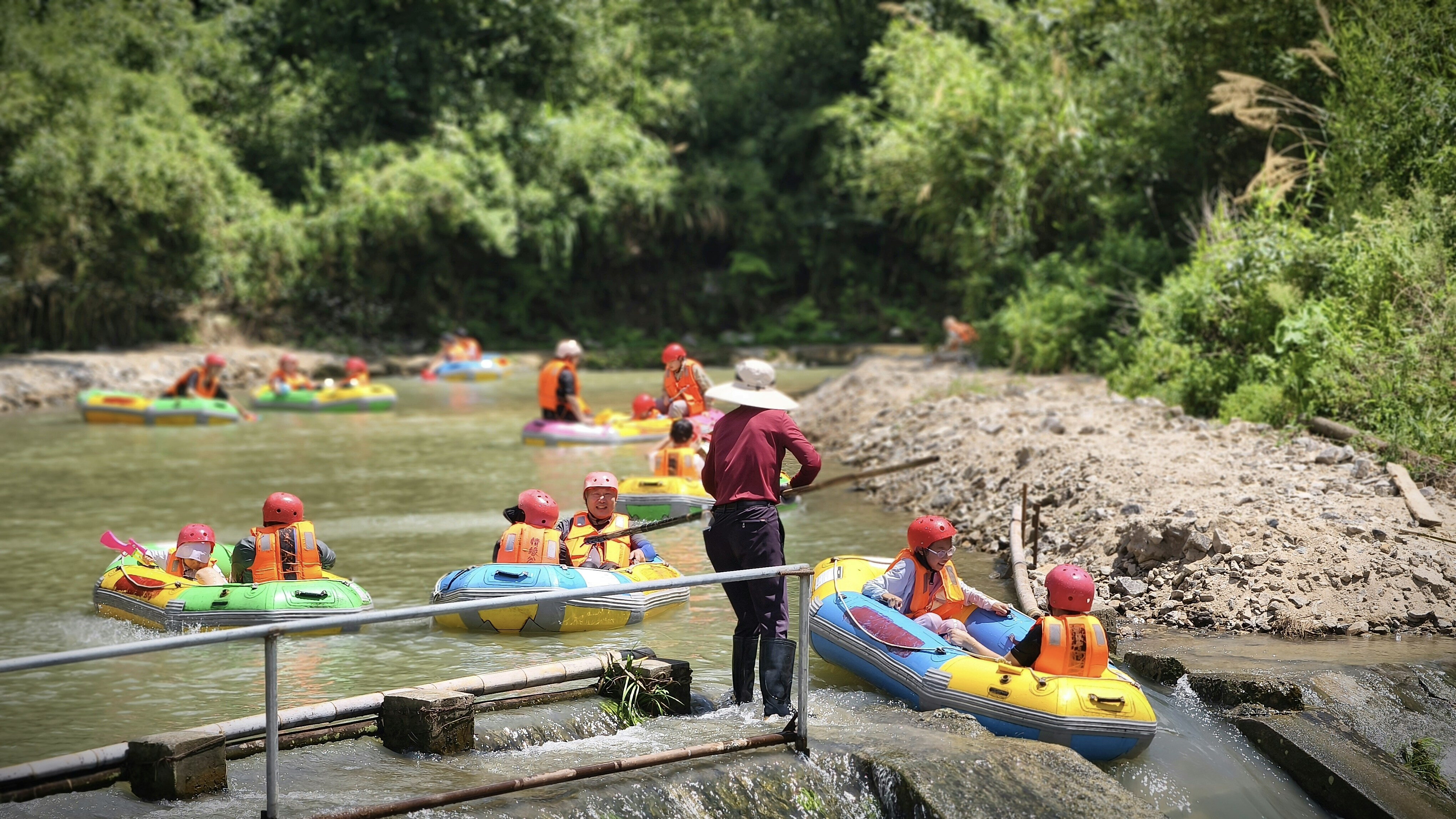 Guide at the Rafting Start: Colorful Rafts Gather Under a Green Canopy