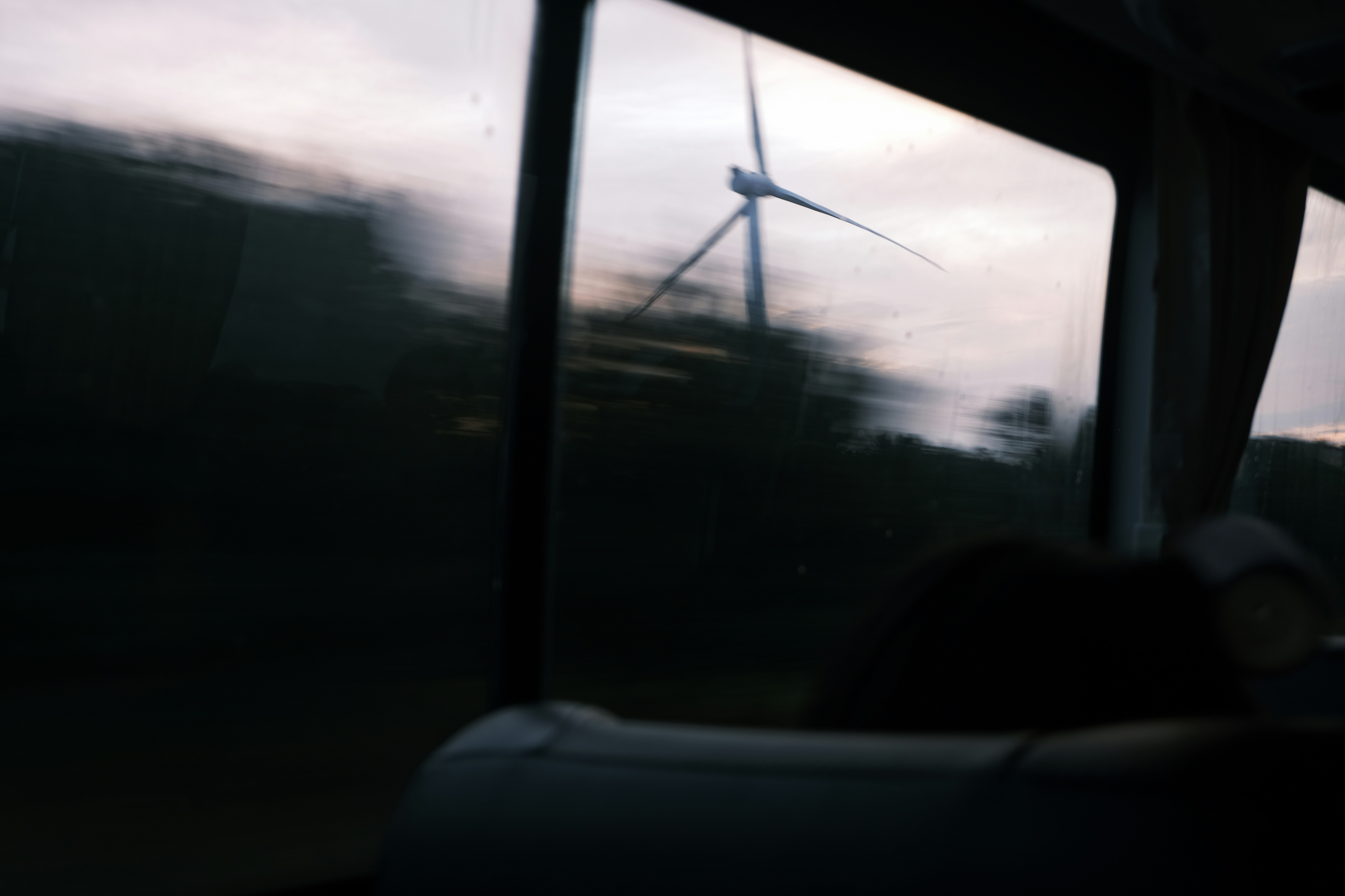 Blurred Window Dream: Wind Turbine Seen Through Bus Window