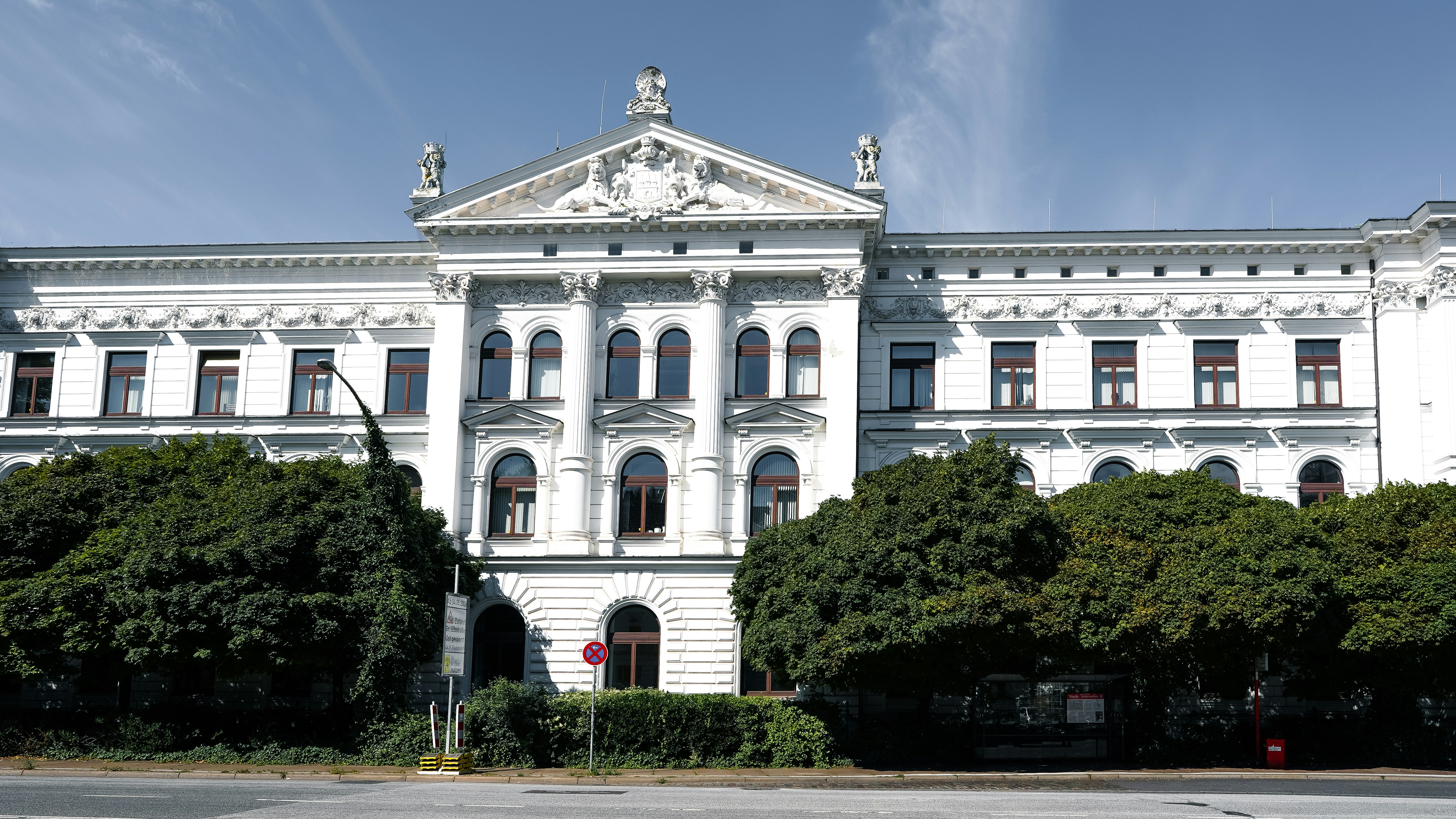Grand Central Facade: A Classical Civic Building Framed by Lush Arboreal Canopy