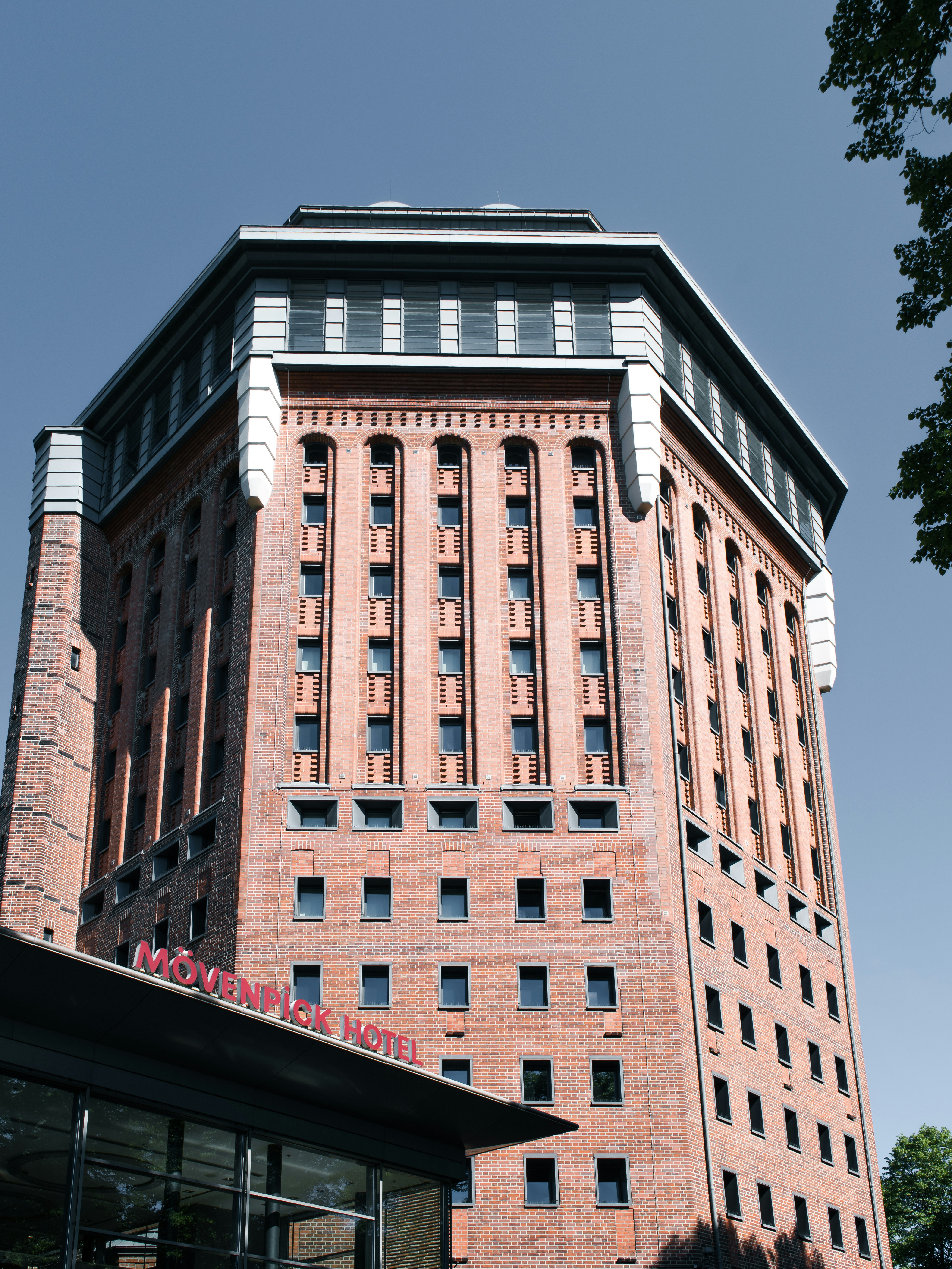 Brick Facade Ascending: The Movenpick Hotel Tower Reaches Toward a Clear Western Sky