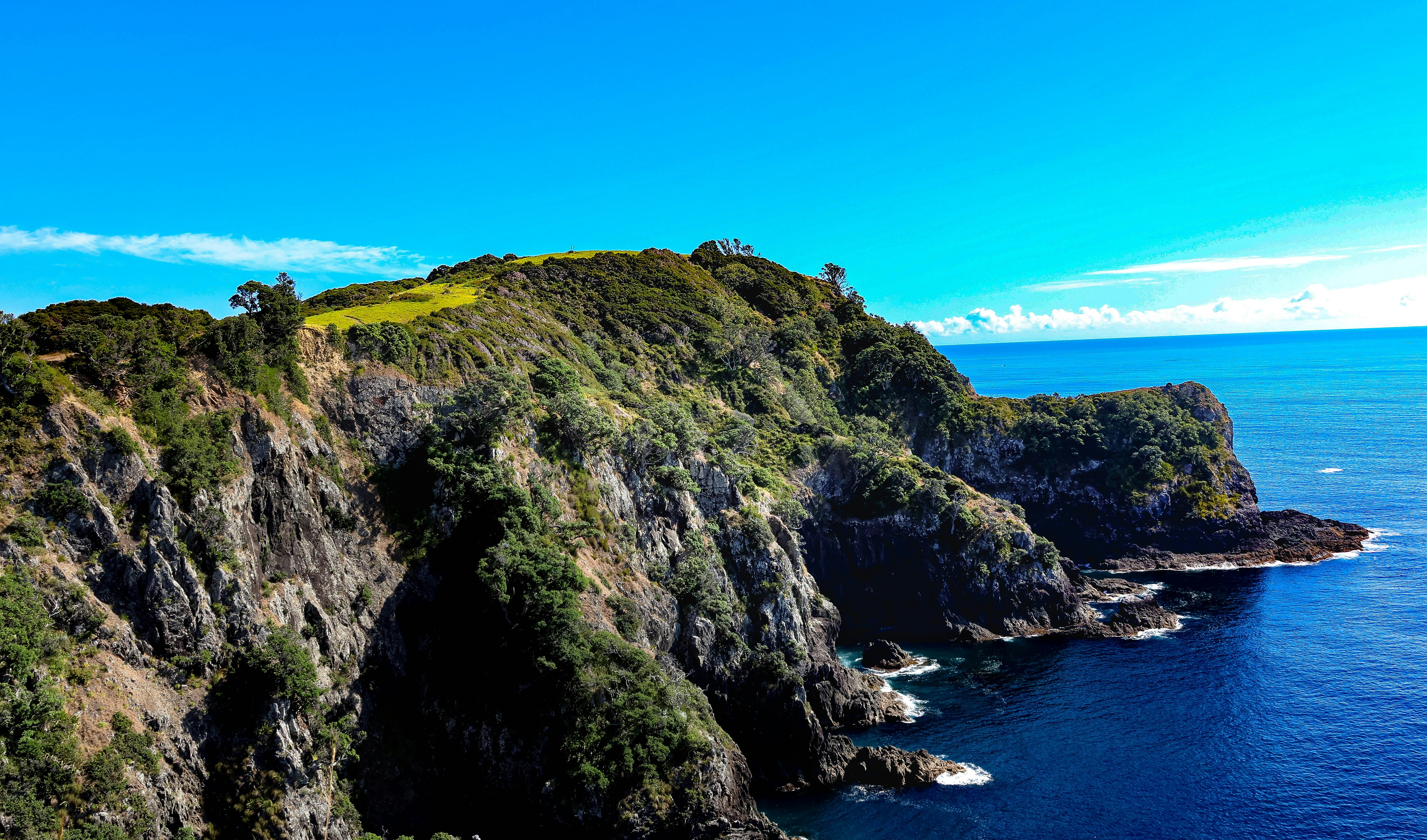 Cliffside Vista: Sunlit Green Promontory Above Turquoise Sea