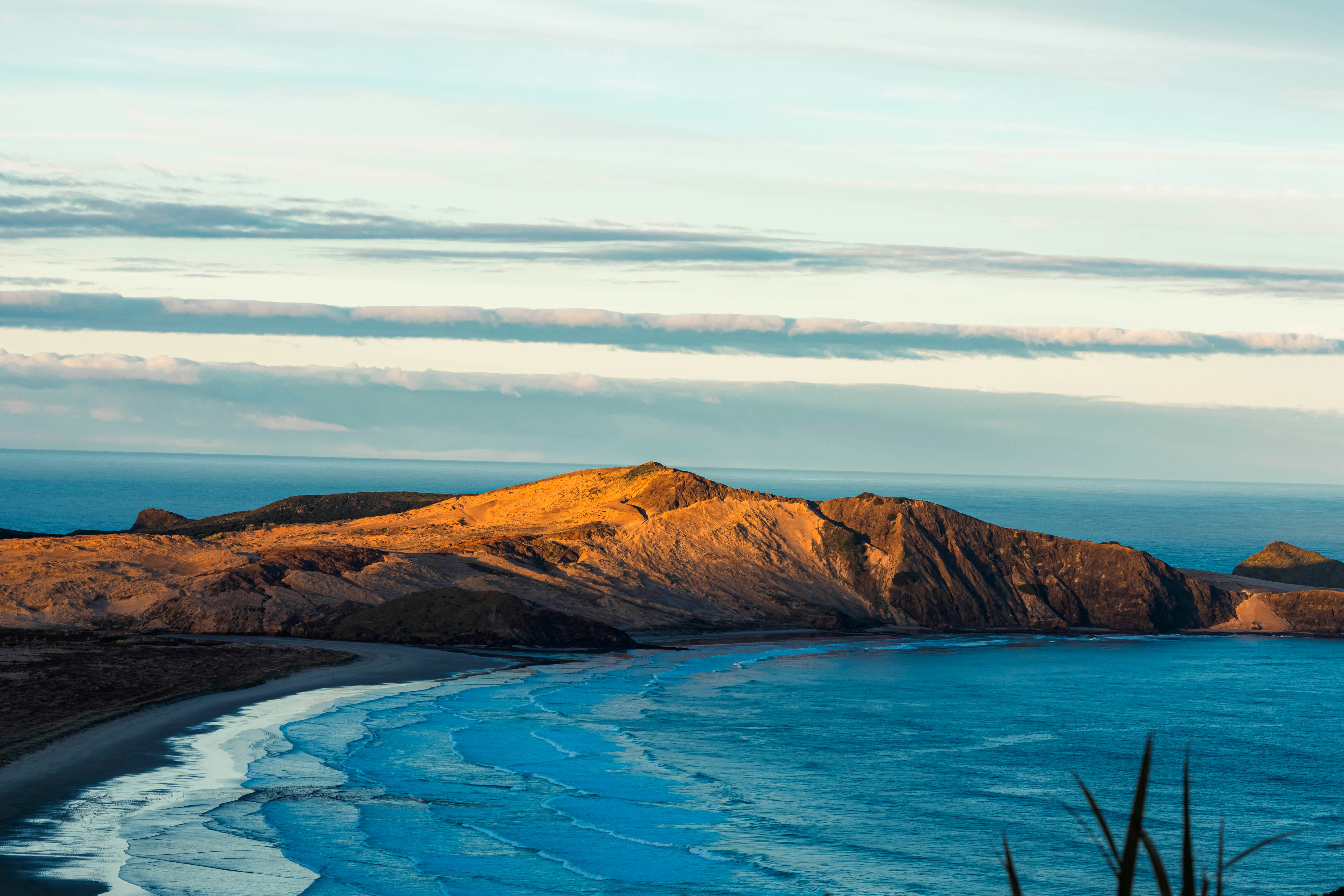 Golden Crest: Sunlit Ridge Over a Sapphire Shore