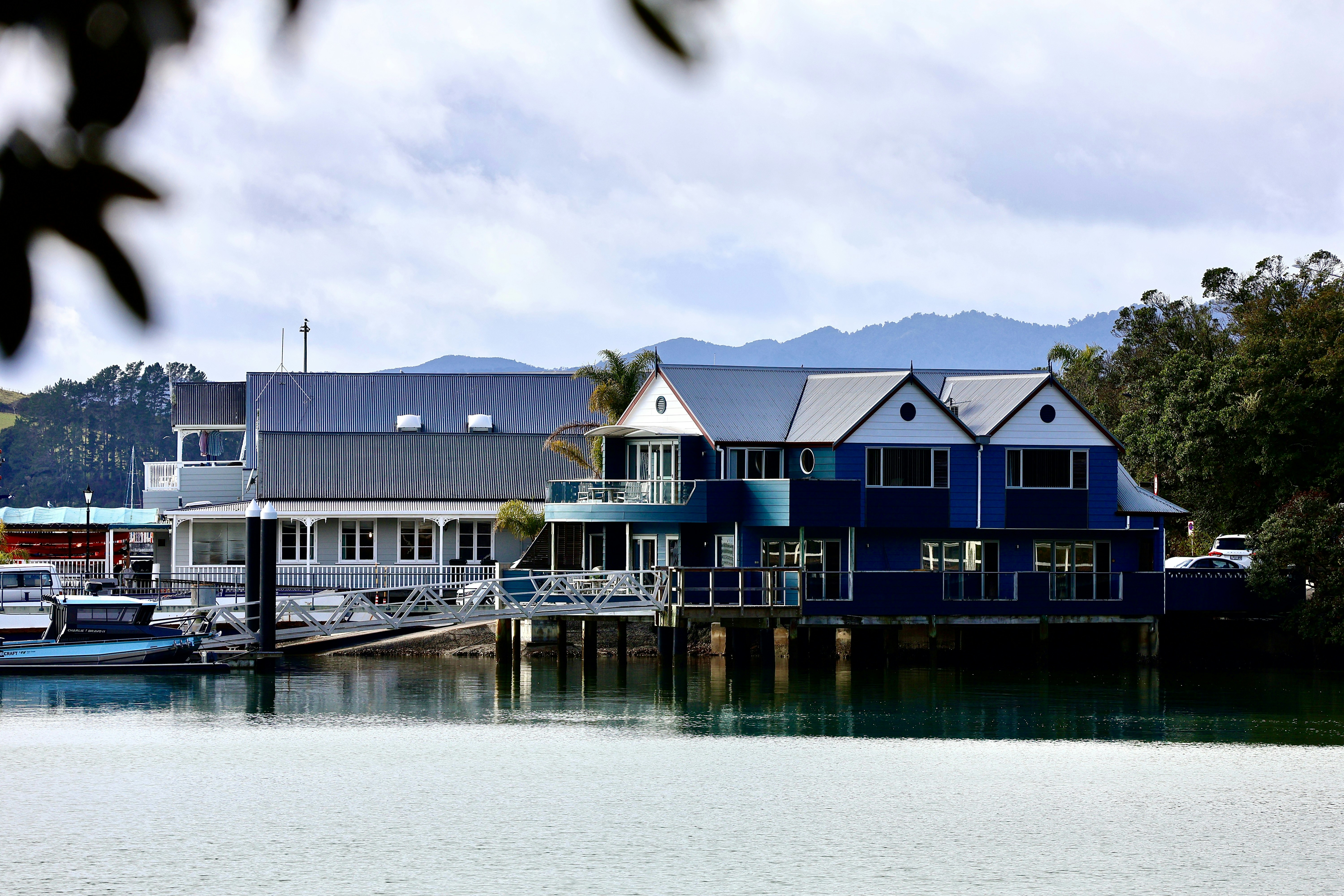 Colorful waterfront cabins rise above glassy water by a tranquil harbor
