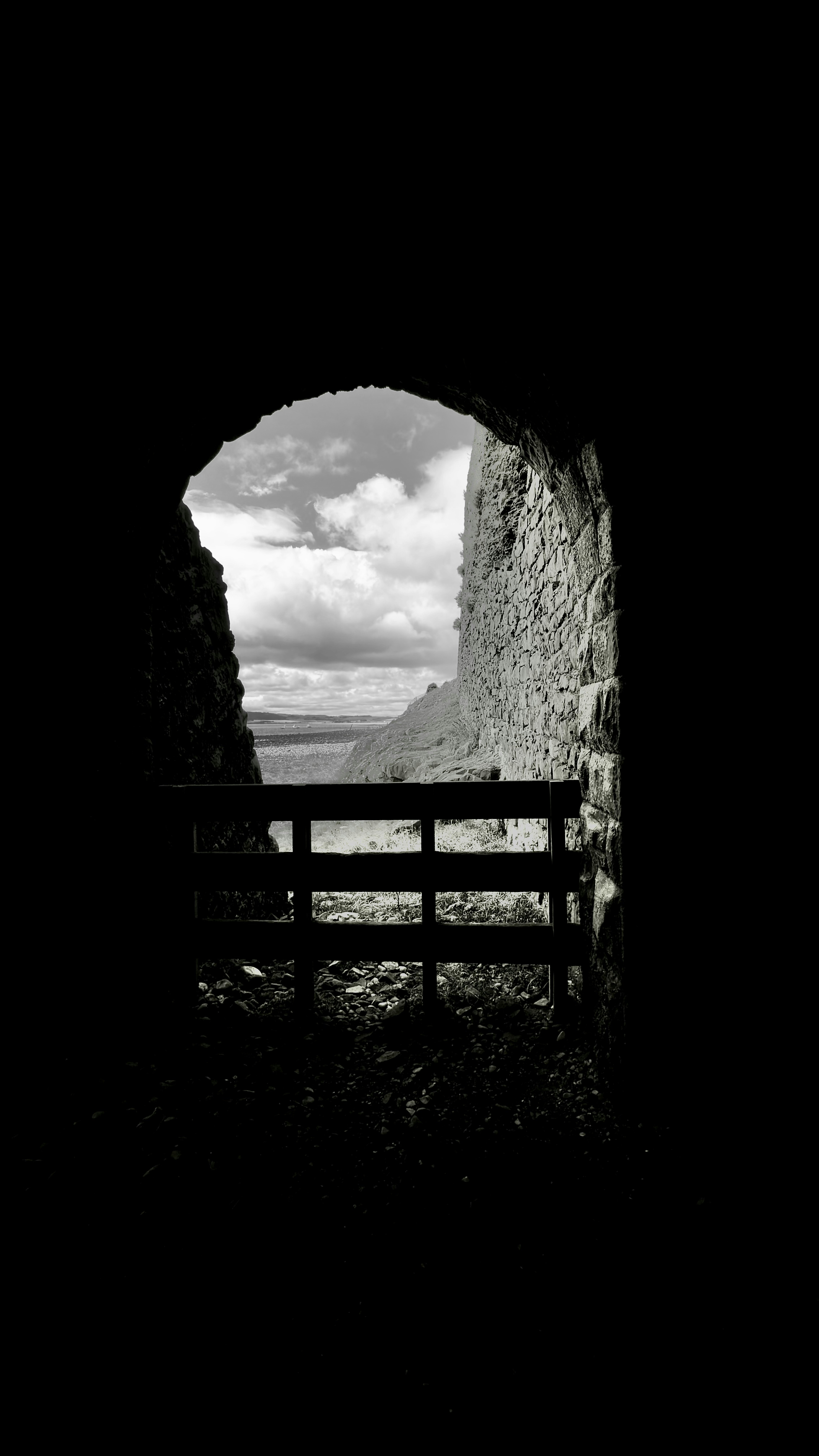 Gateway to Light: Coastal Cliff Vista Through a Dark Arch