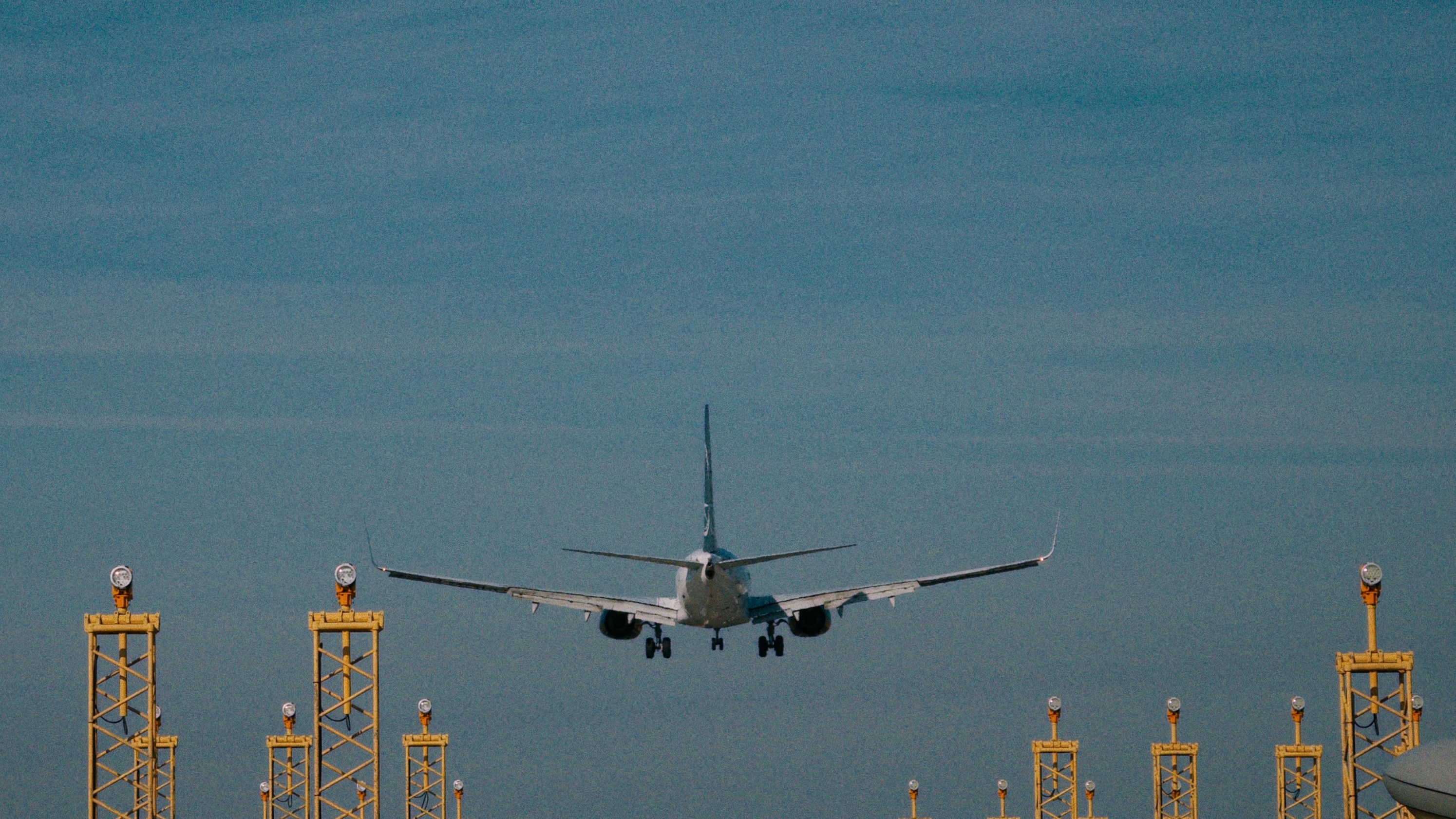Approaching Wingtip: A Passenger Jet Descends Between Ground Structures