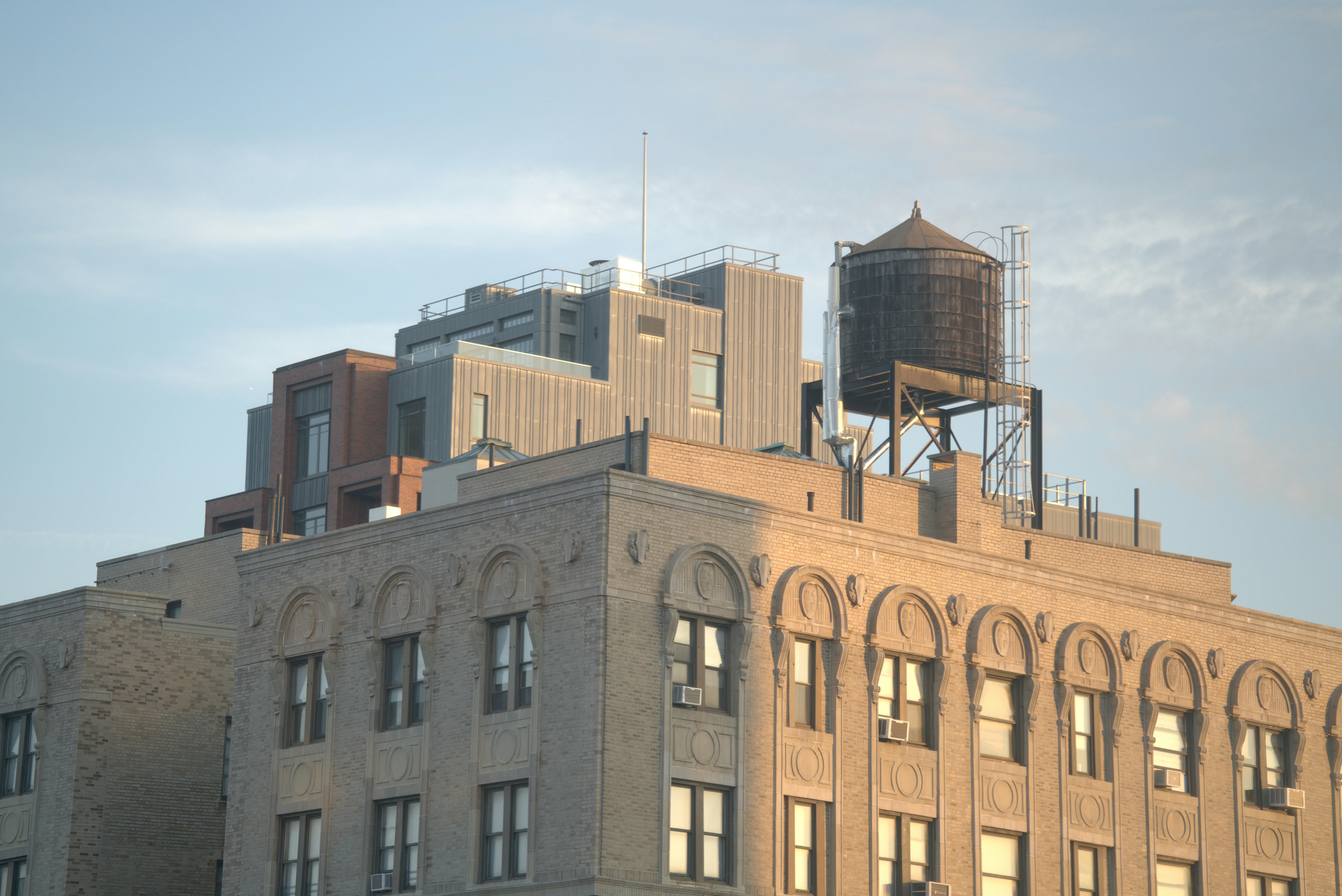 Rooftop Machinery and Arched Facade: An Urban Brickwork Portrait