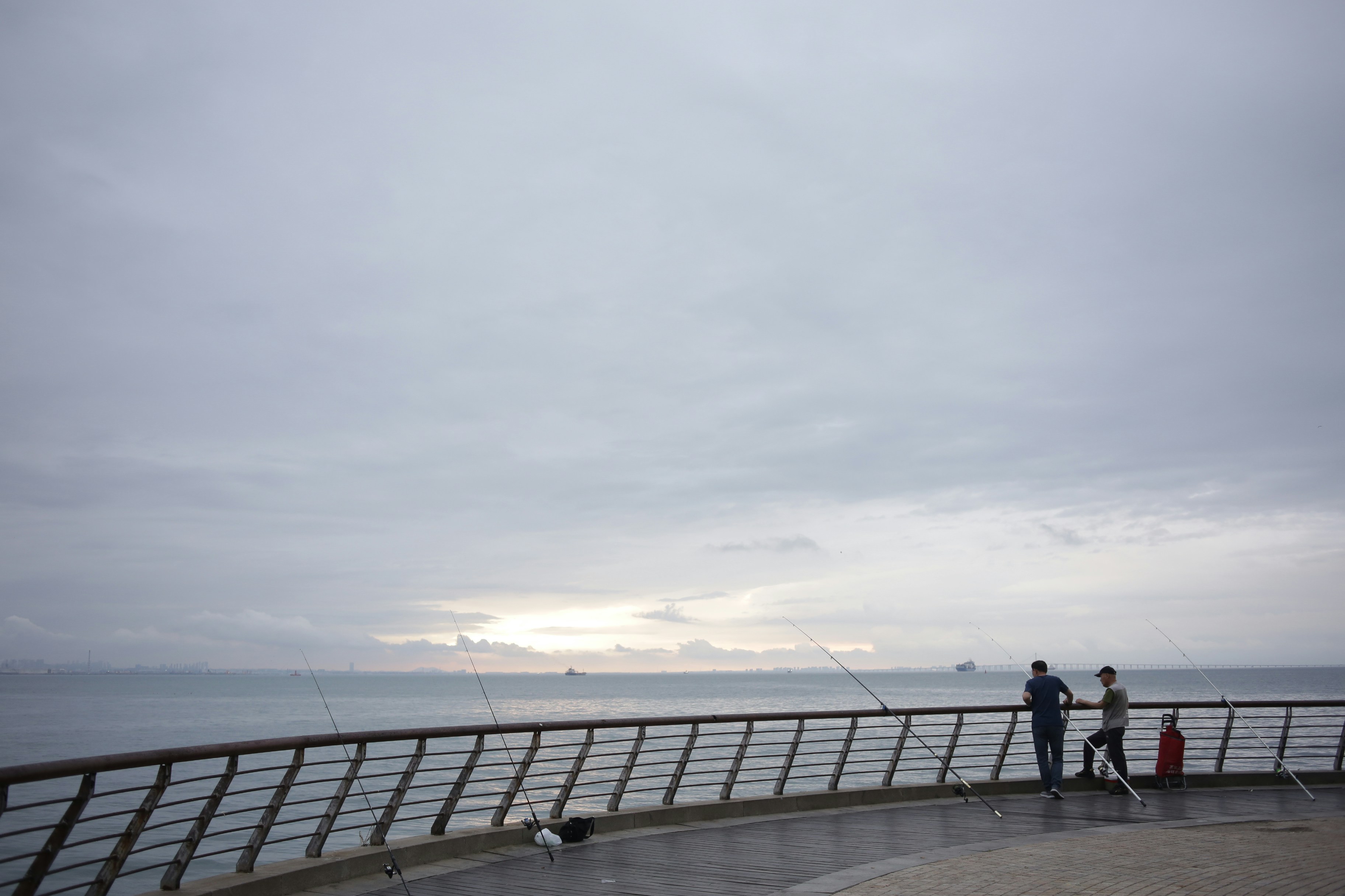 Seaside Promenade at Dusk: A Quiet Moment by the Rail