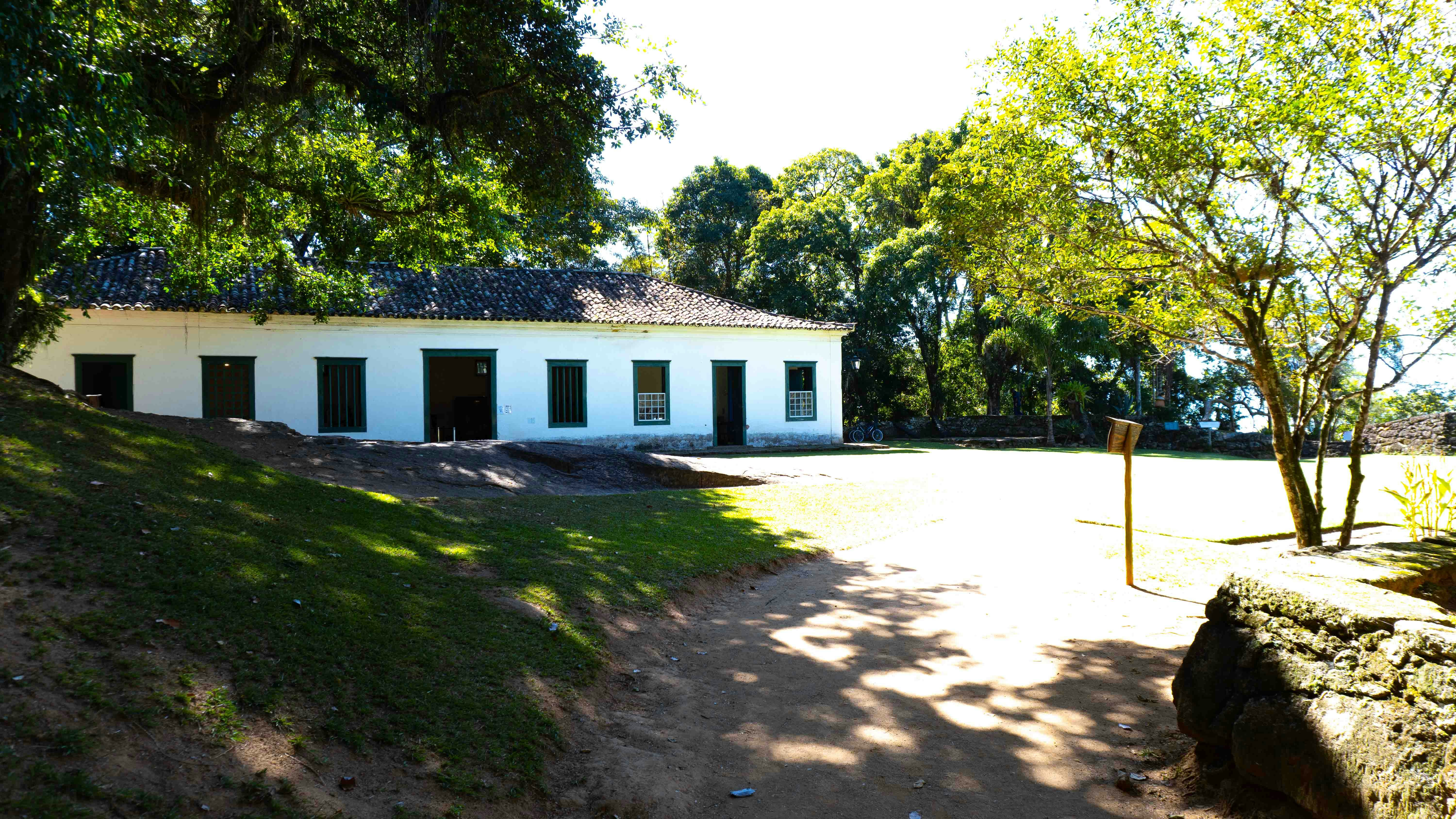 White colonial building by a sun-dappled path