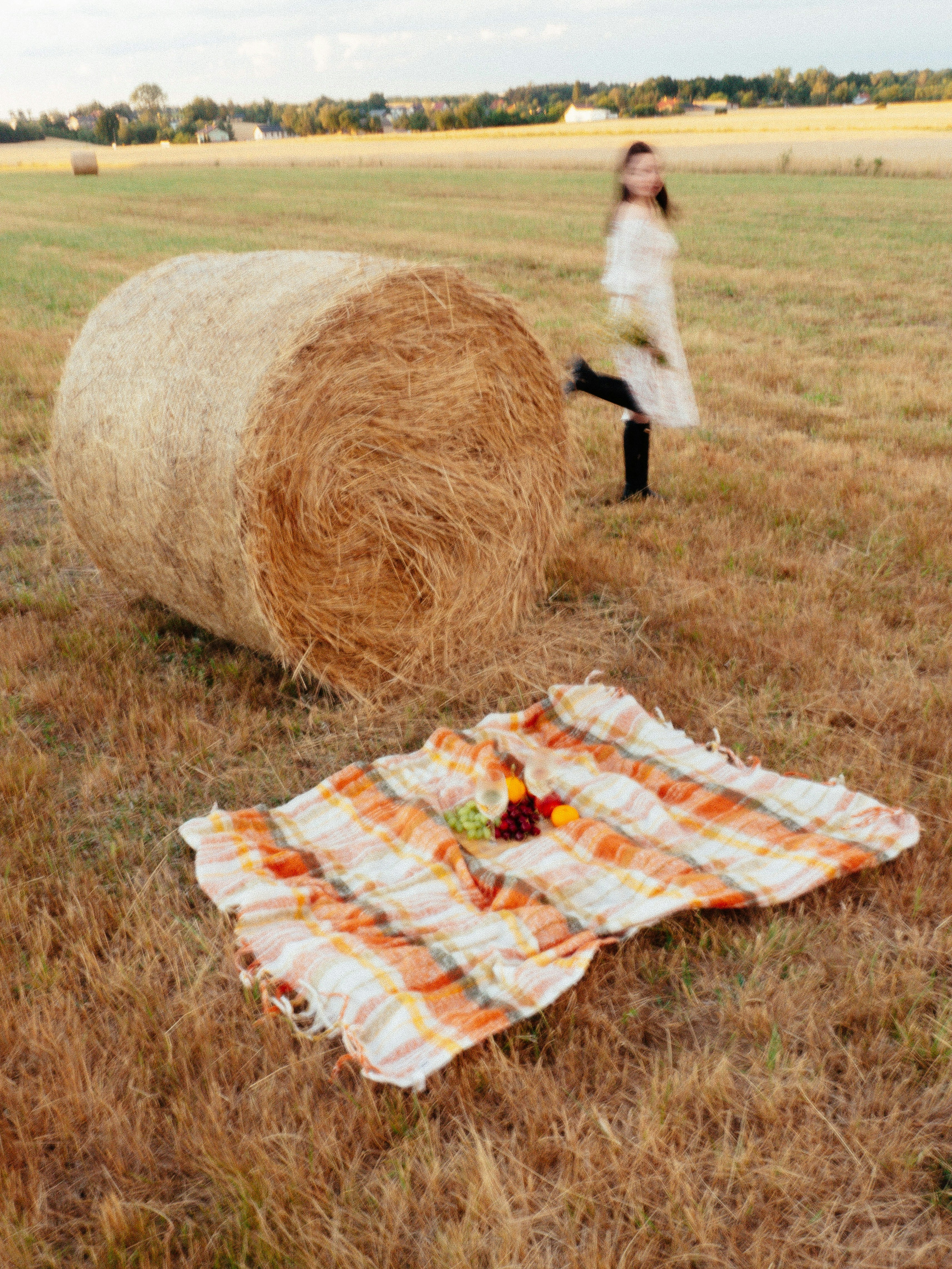 Harvest Picnic: Hay Bale, Blanket, and a Quiet Figure in a Golden Field