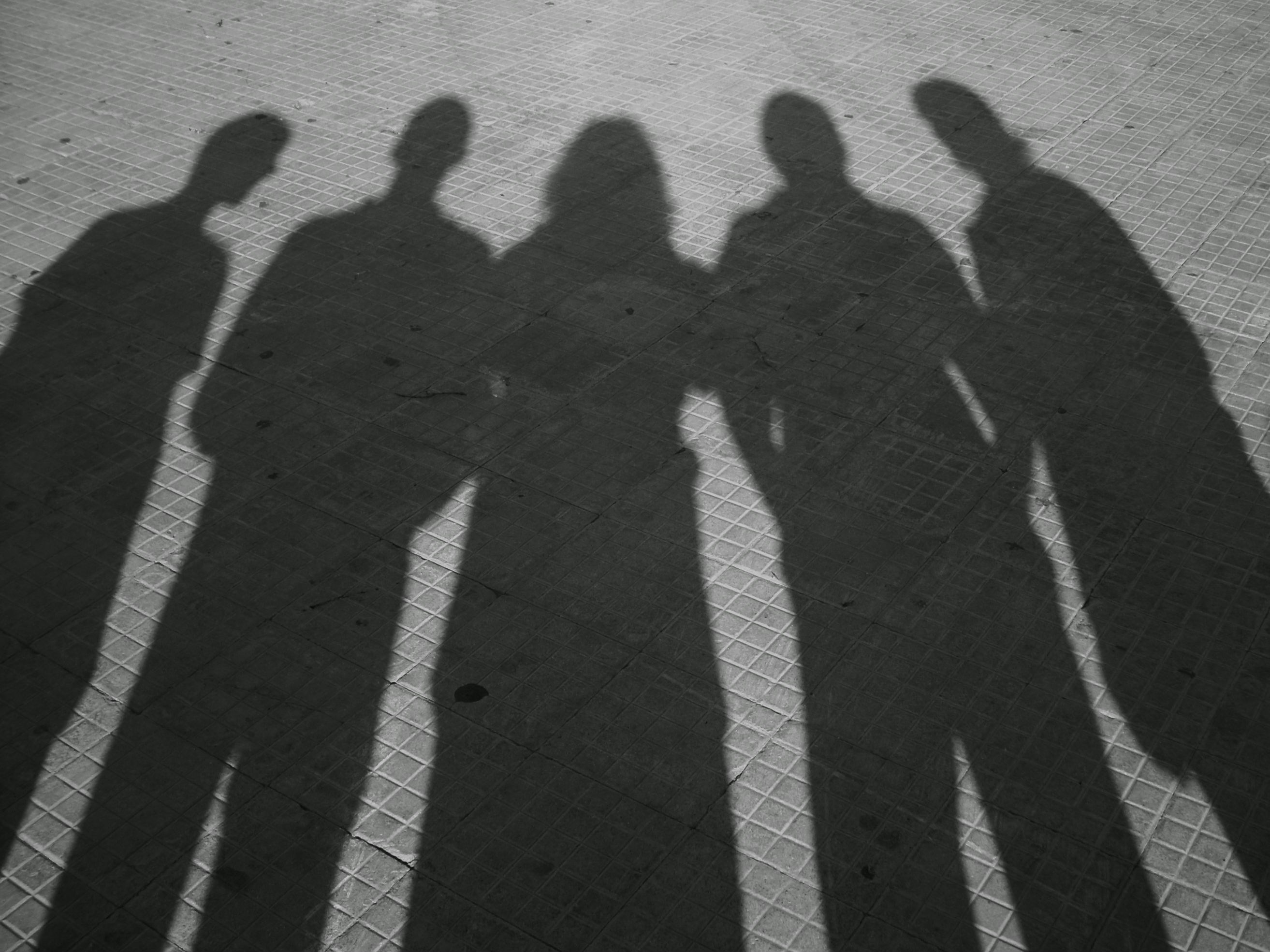 Shadow Lineup: Silhouetted Friends on a Gridded Ground