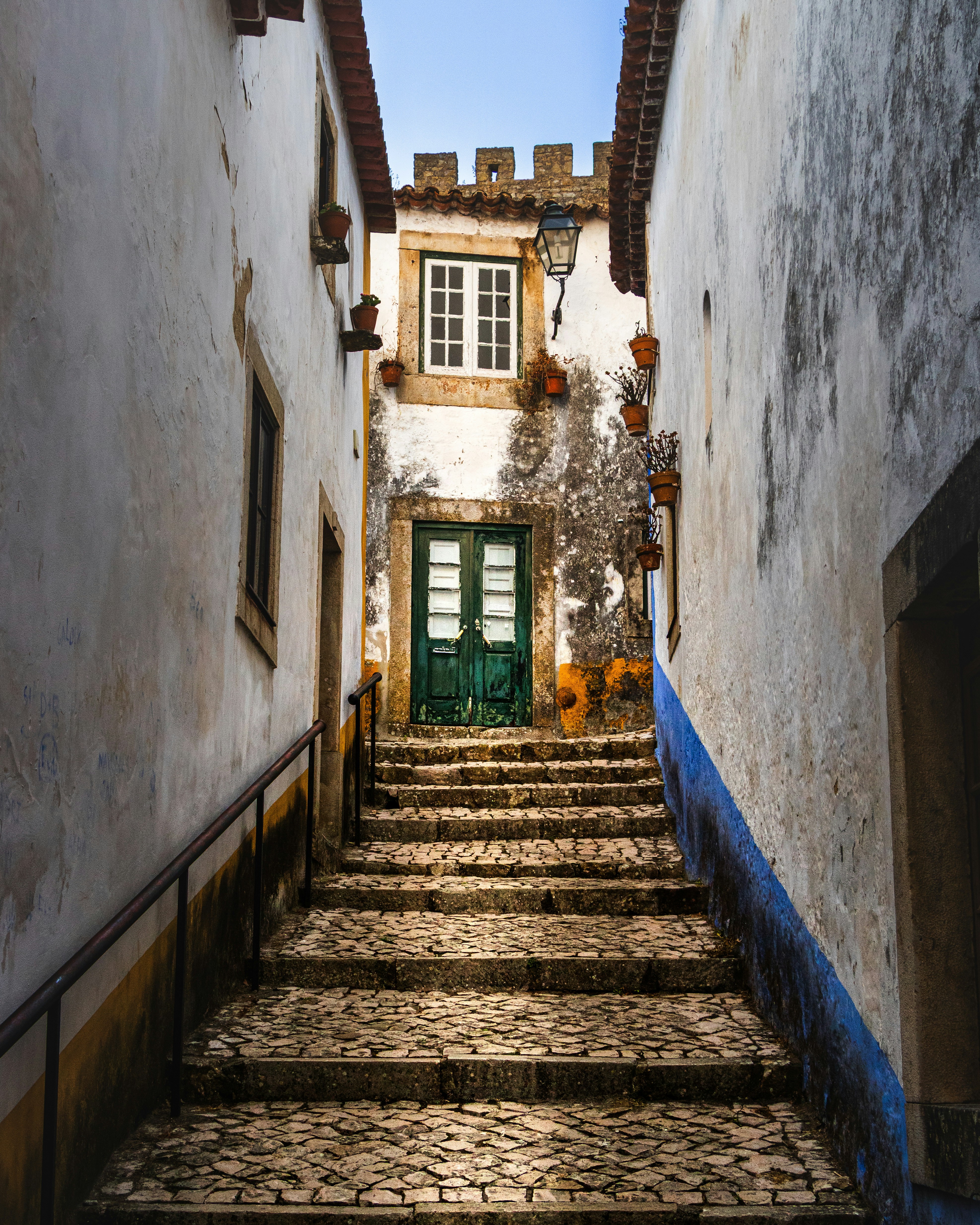 Sunlit Green Door at the Top of Cobblestone Steps