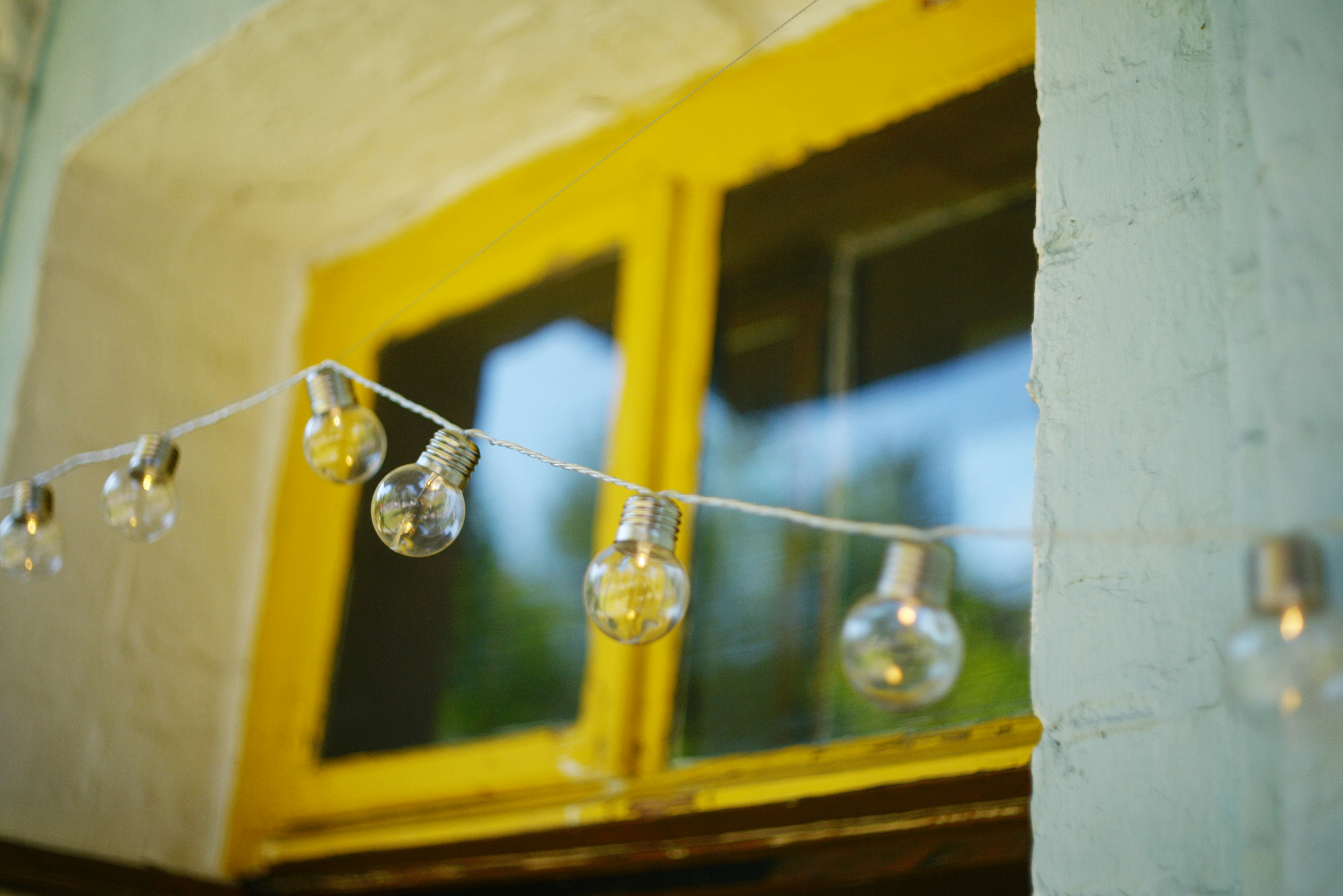 Sunlit Yellow Window Framed by String Lights