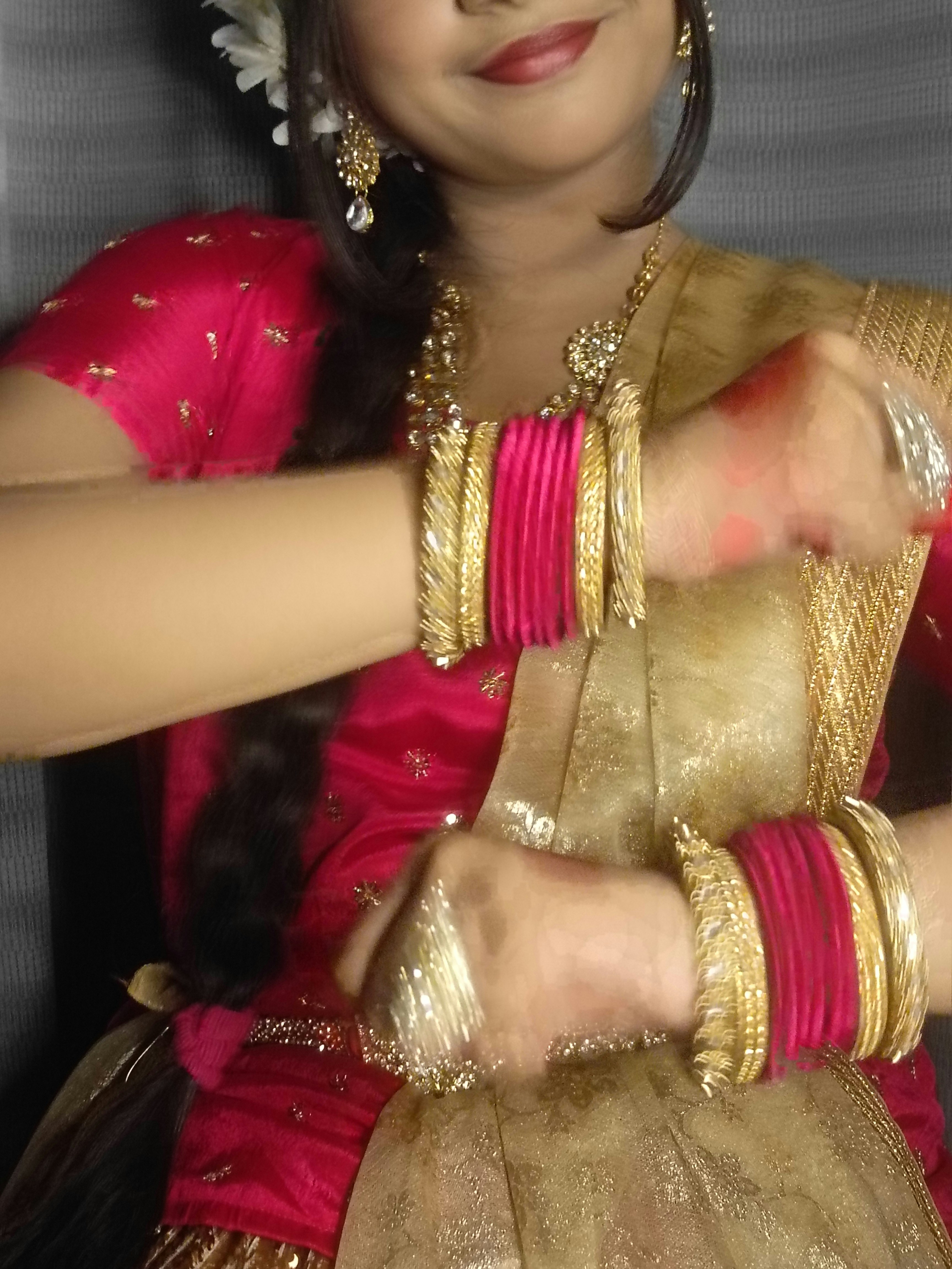 Vibrant Portrait of a Traditional Dancer Adorned in Gold and Pink Bangles