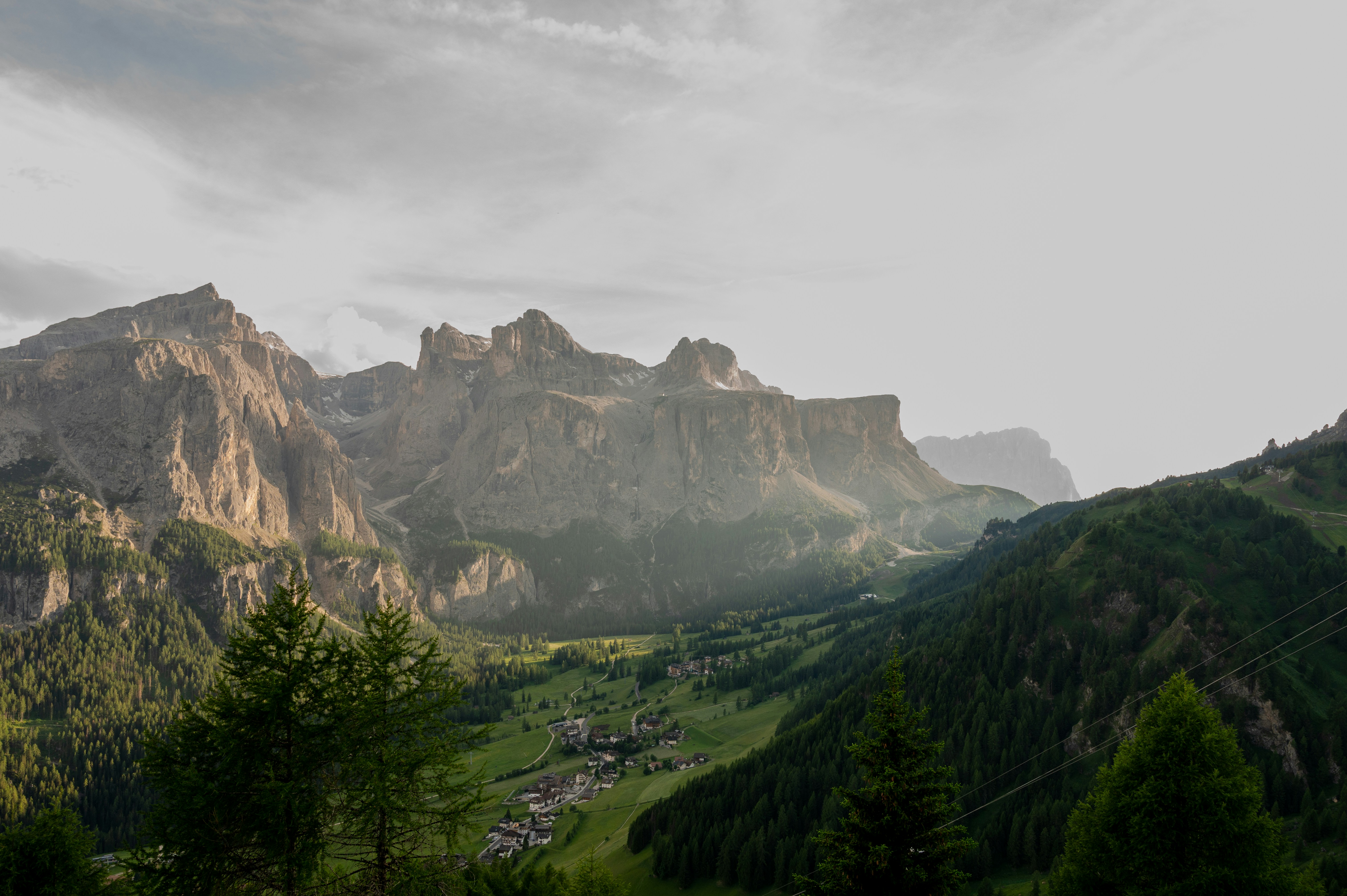 Sunlit Alps: Village Veil Beneath Craggy Peaks