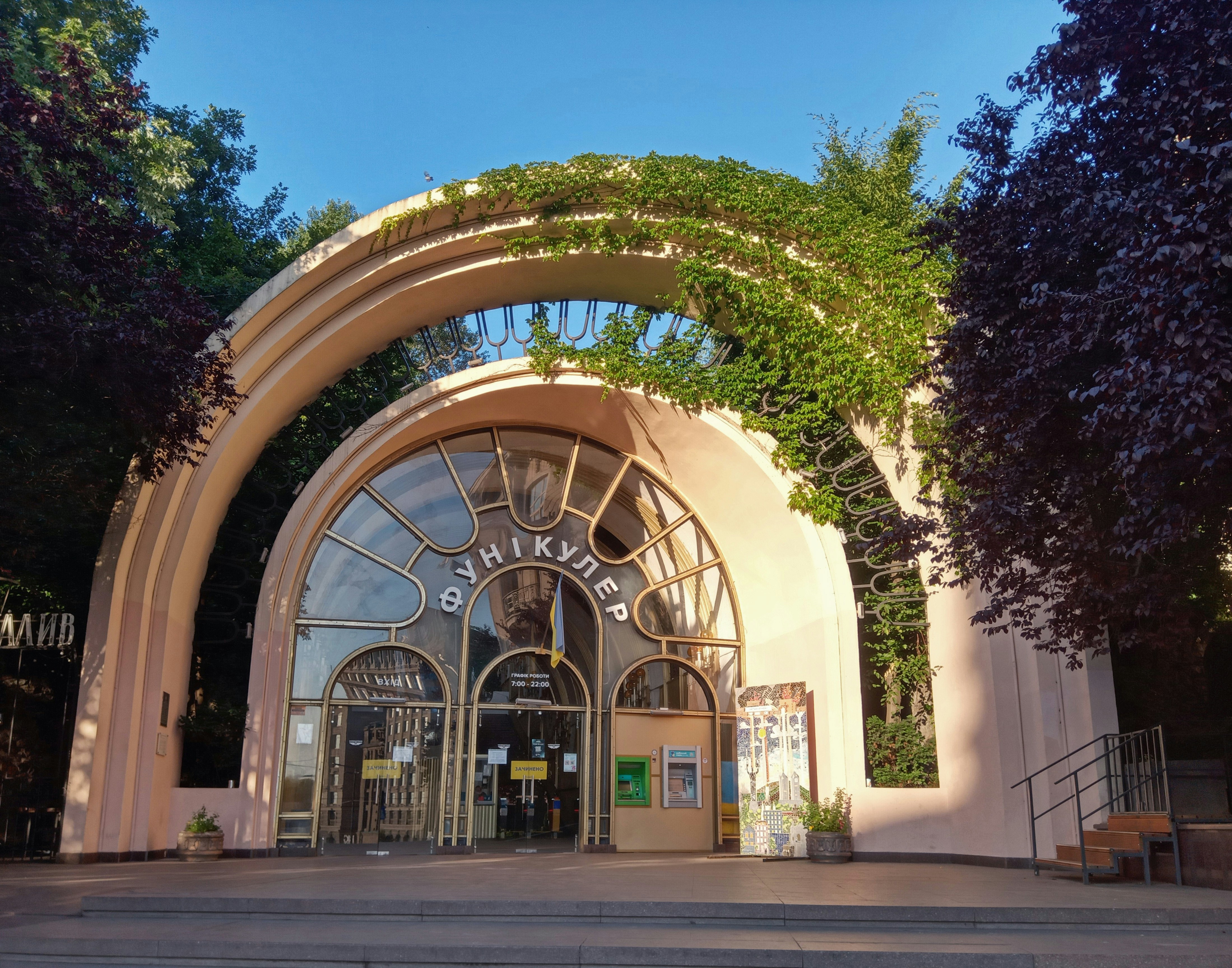 Arched Gallery Entrance Cloaked in Ivy under Clear Spring Sky