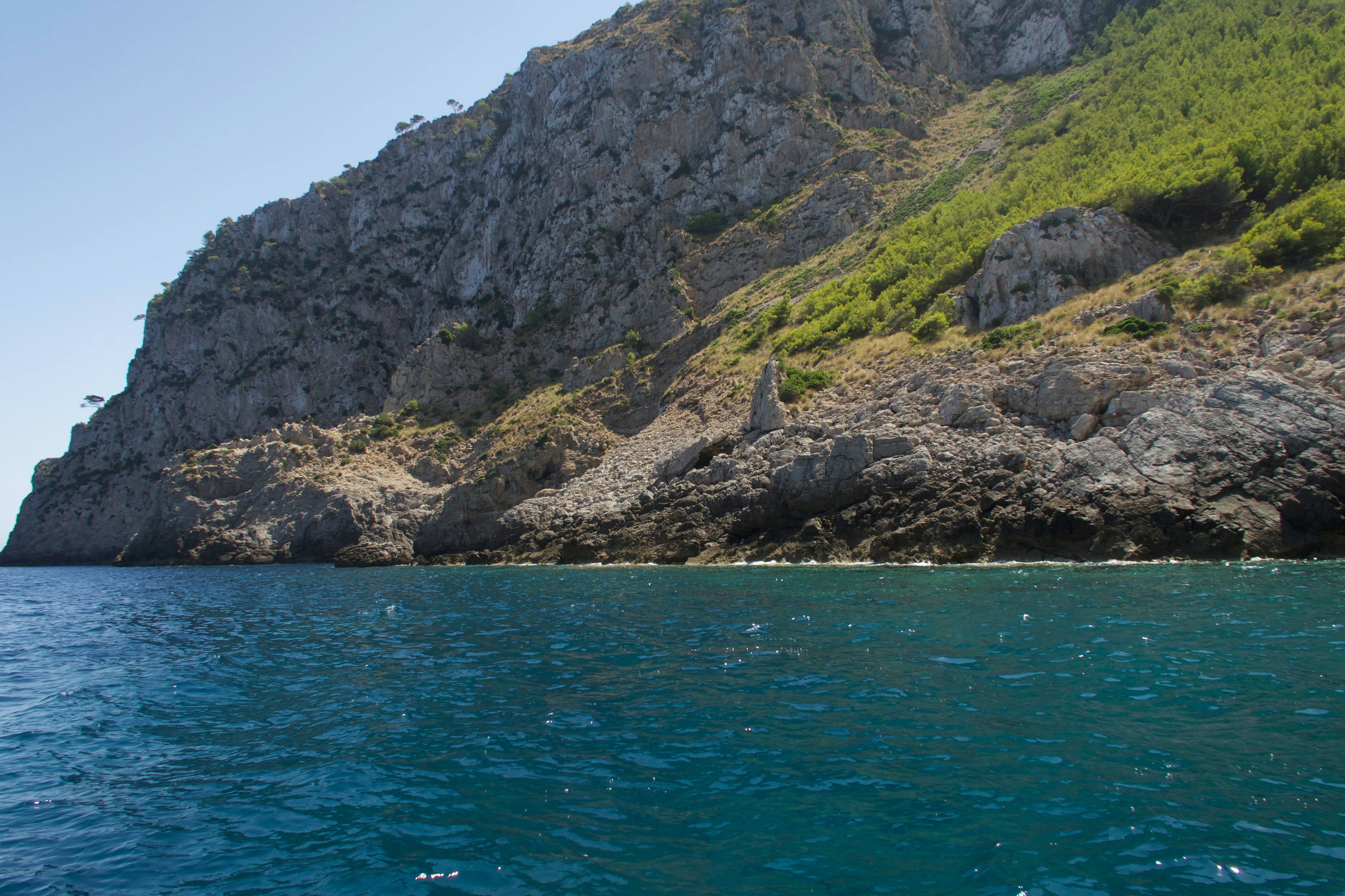 Sunlit Cliffside Over Azure Waters